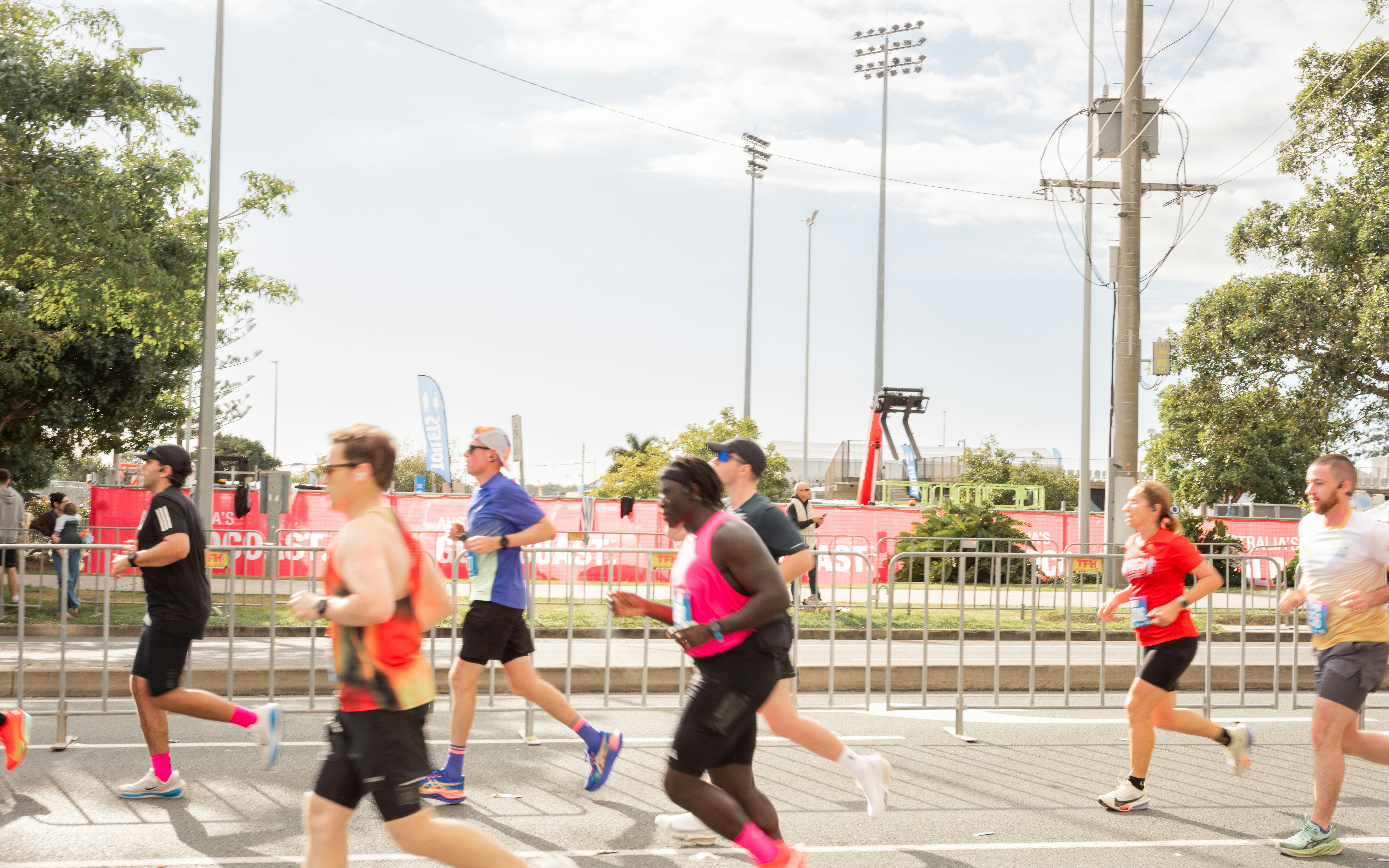 Runners in Motion: City Road Race Under Bright Afternoon Lights