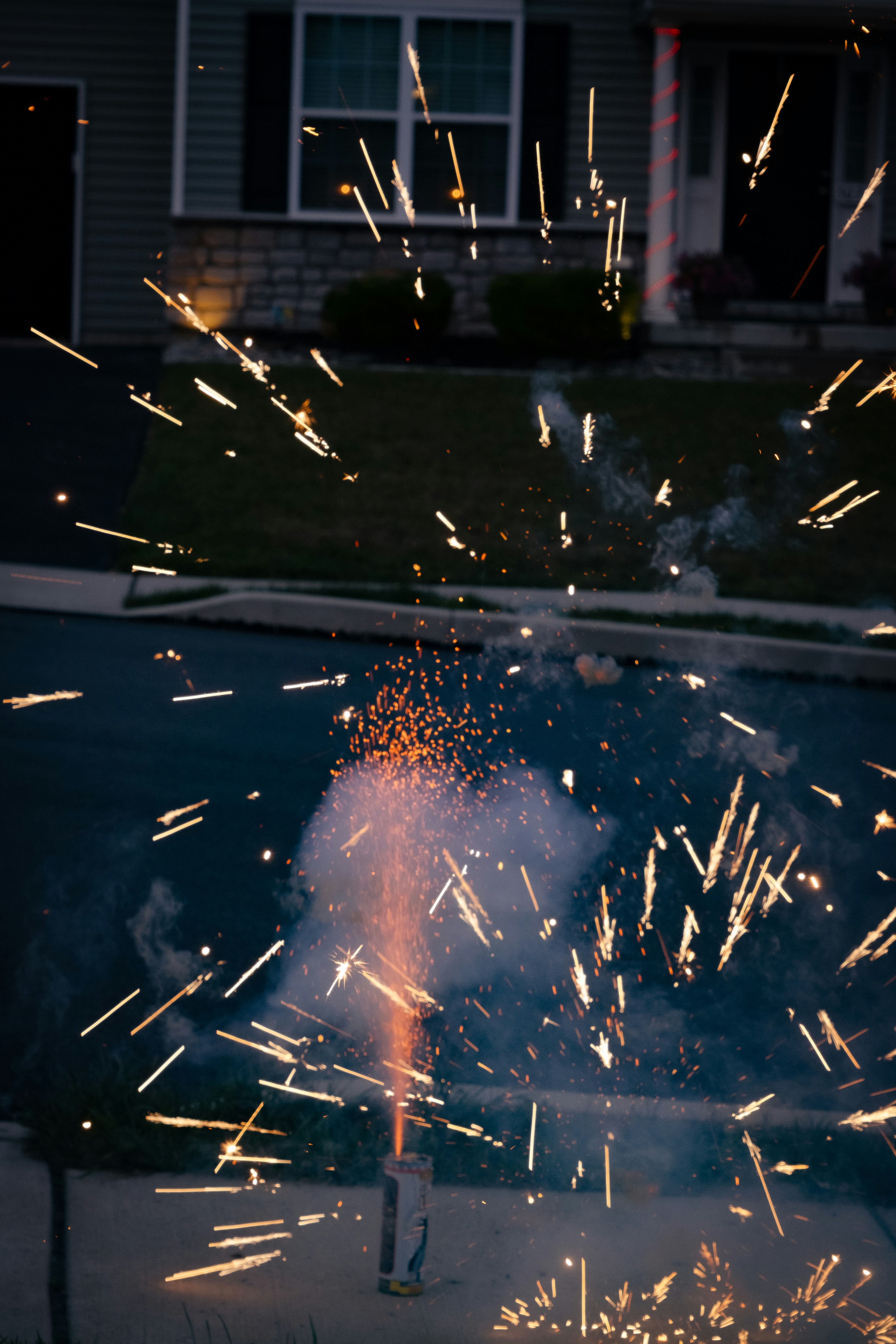 Sparks from exploding ground fireworks illuminate the night.