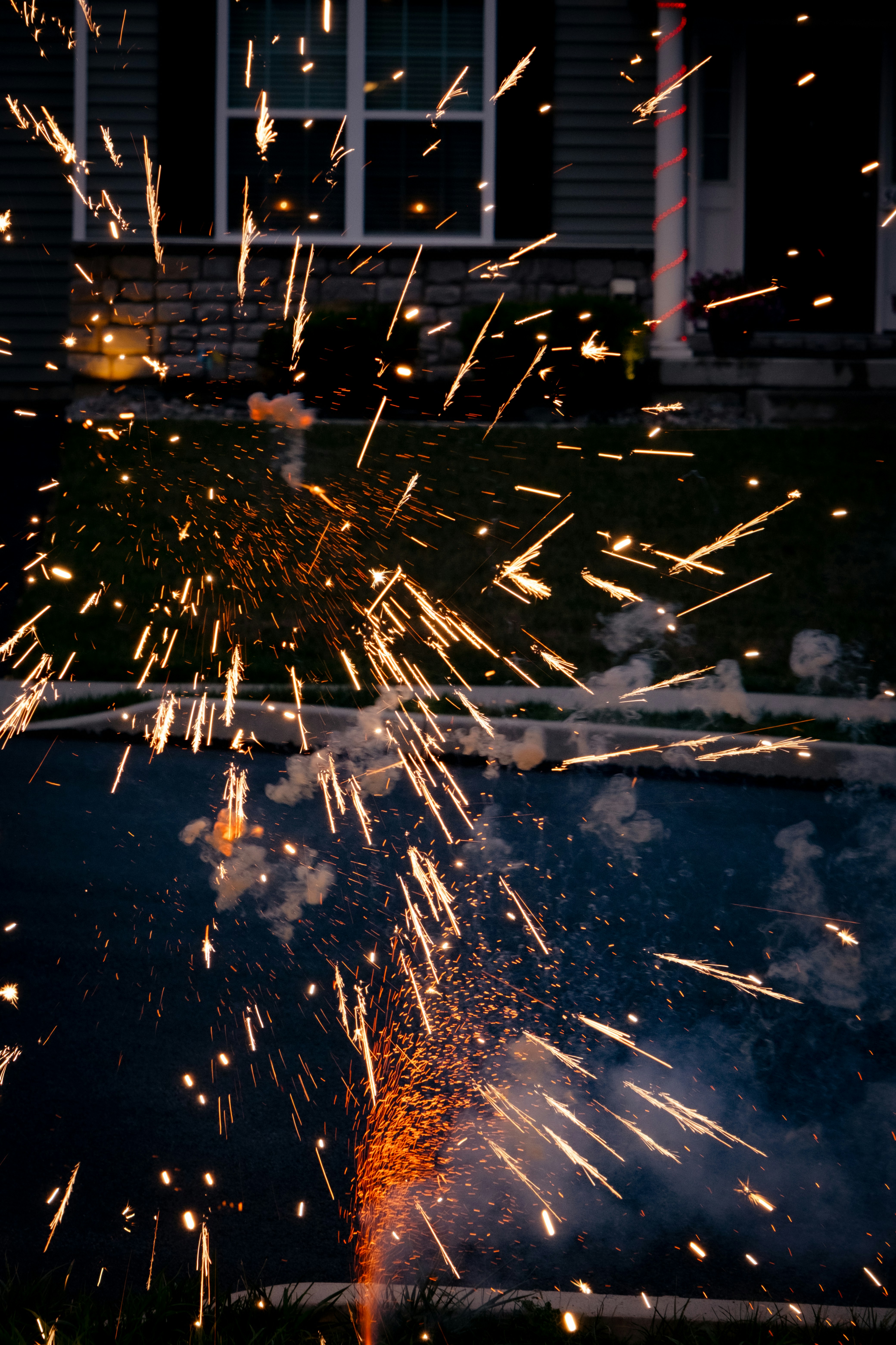 Sparks in the Night: Firework Burst at a Suburban Porch