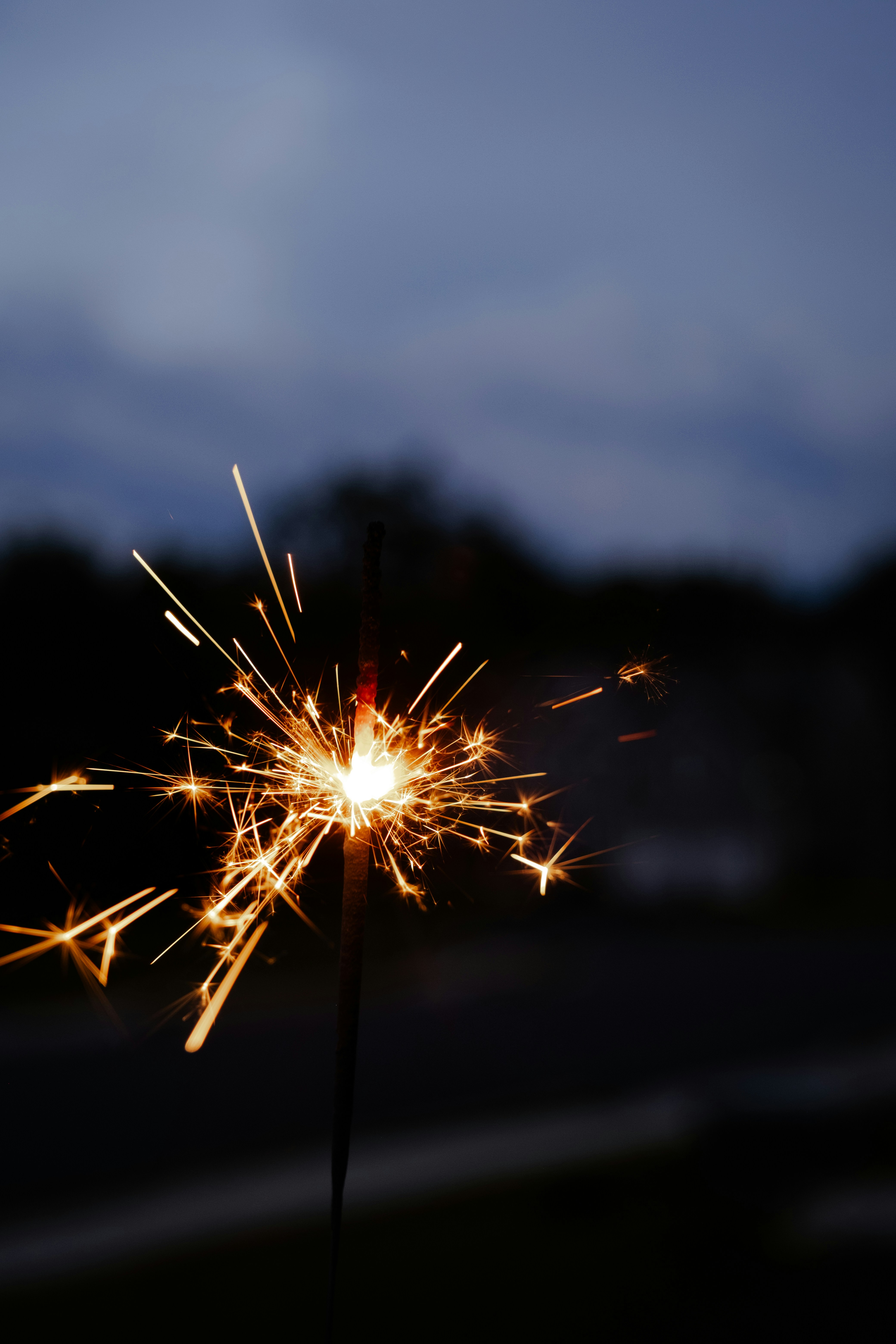Spark at Dusk: A Single Sparkler Against a Velvet Evening