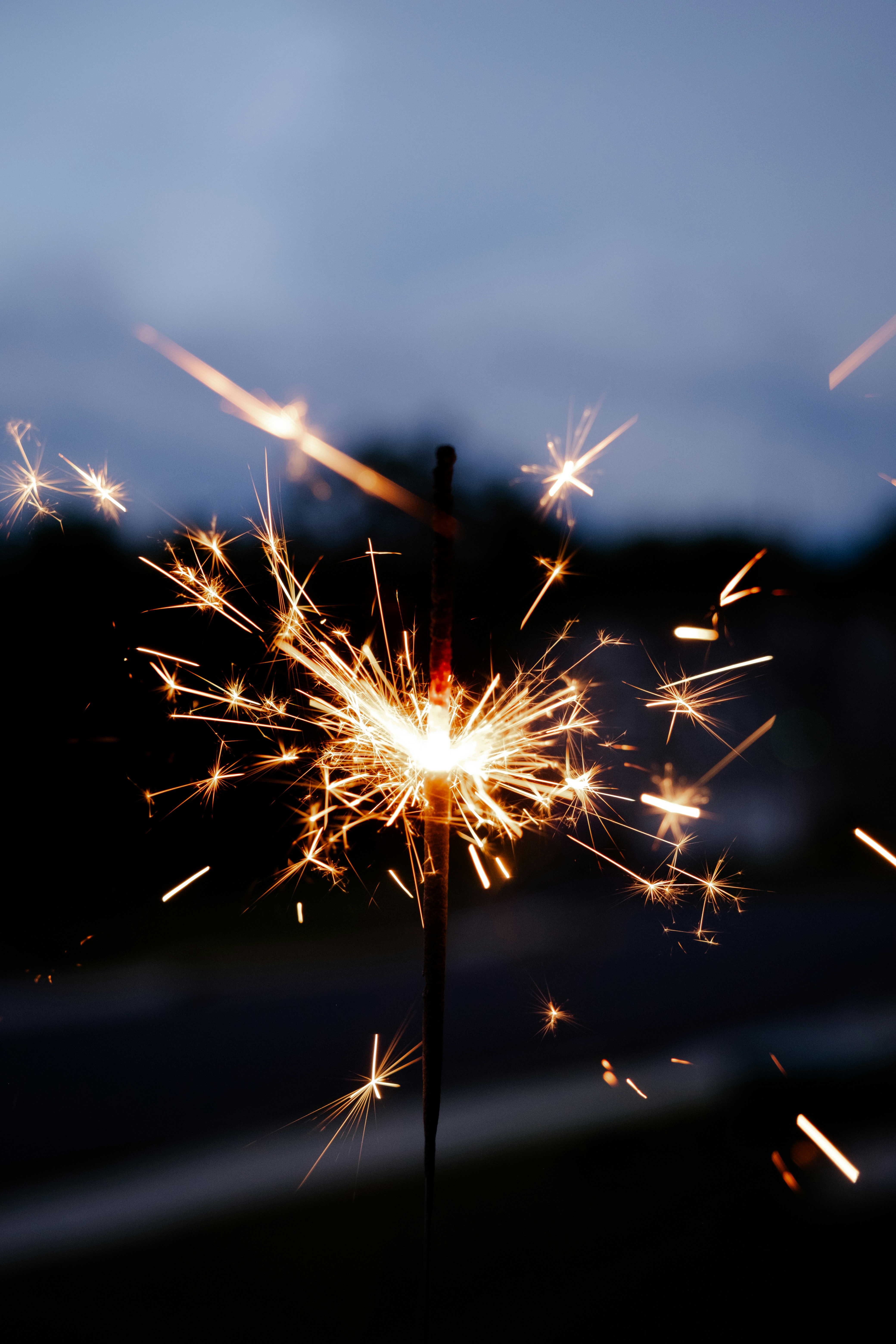 Spark in the Stillness: A Floating Sparkler Against Evening Indigo