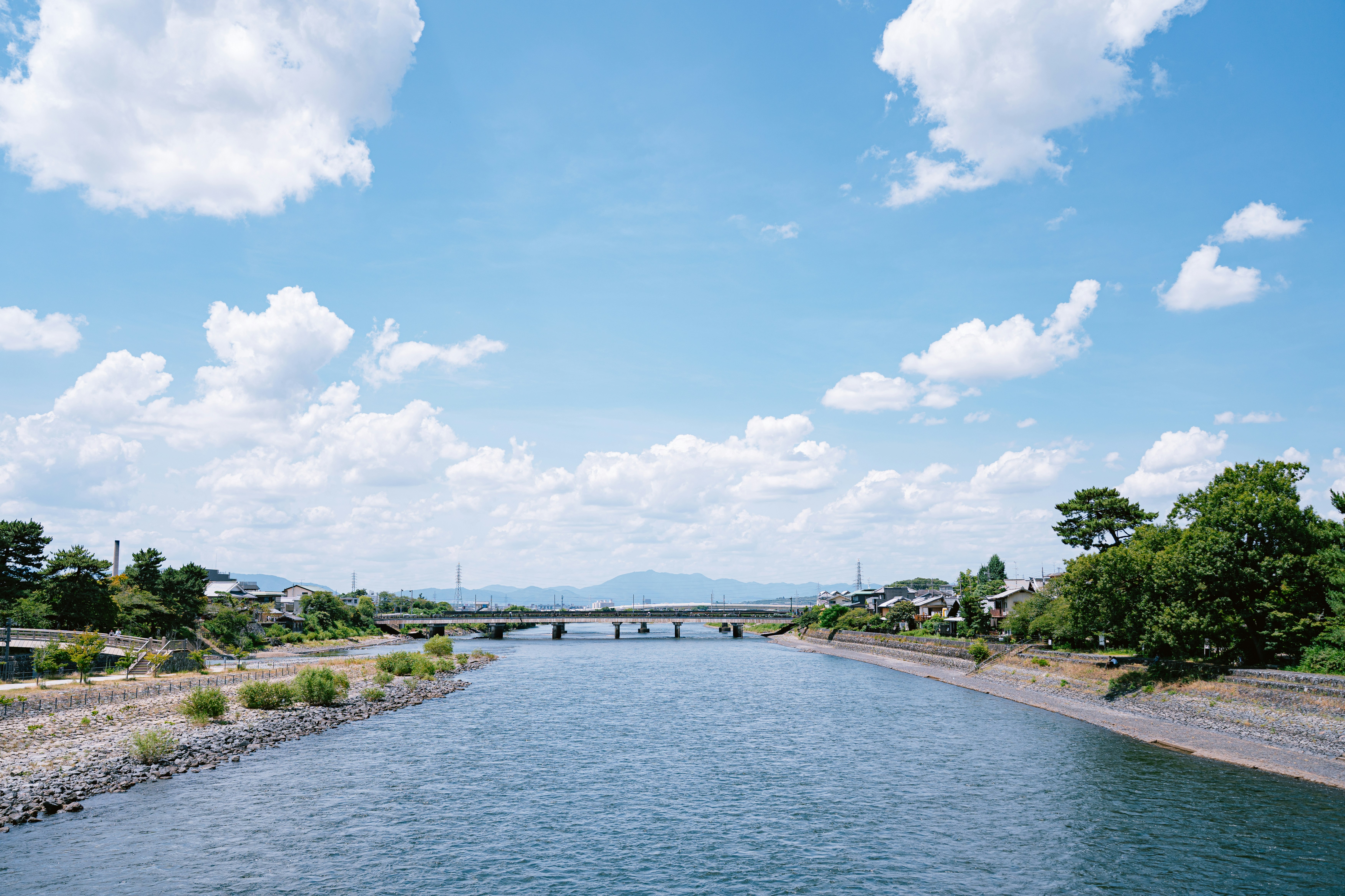 Riverside Confluence under a Vast Summer Sky