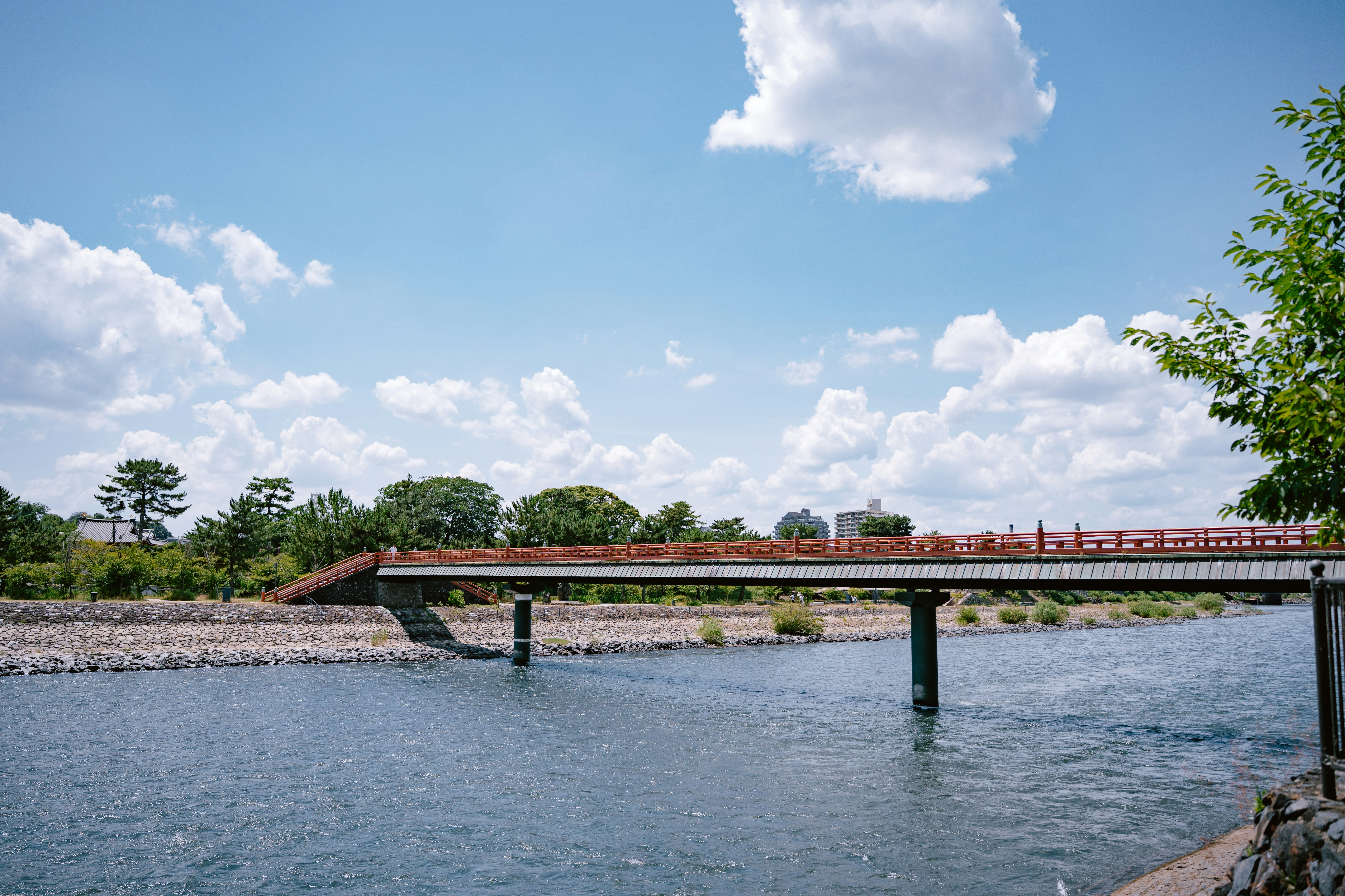 Bridge over calm river under a bright sky