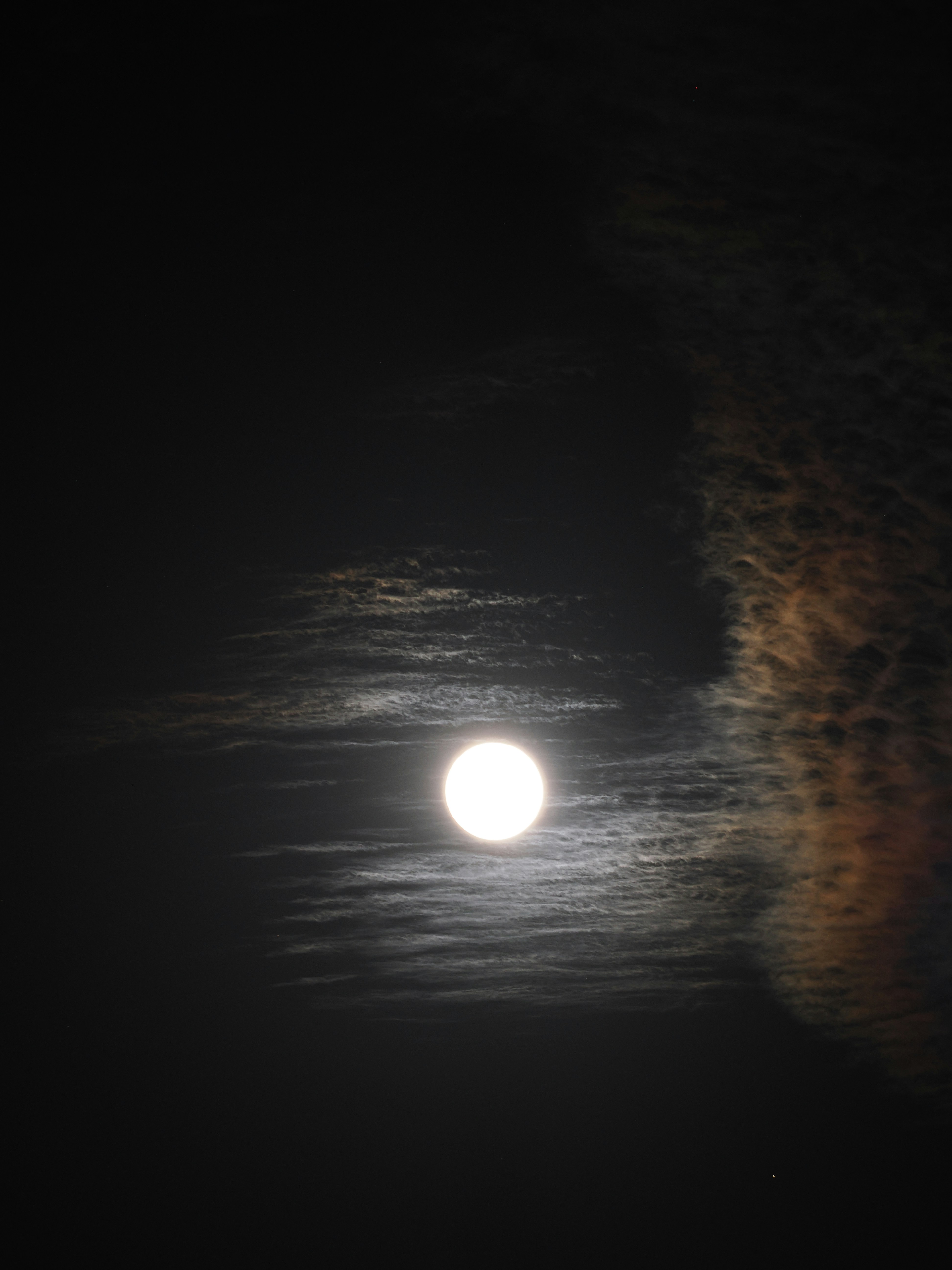 Moonlit Gale: A Quiet Night Sky with a Bright Orb and Soft Clouds