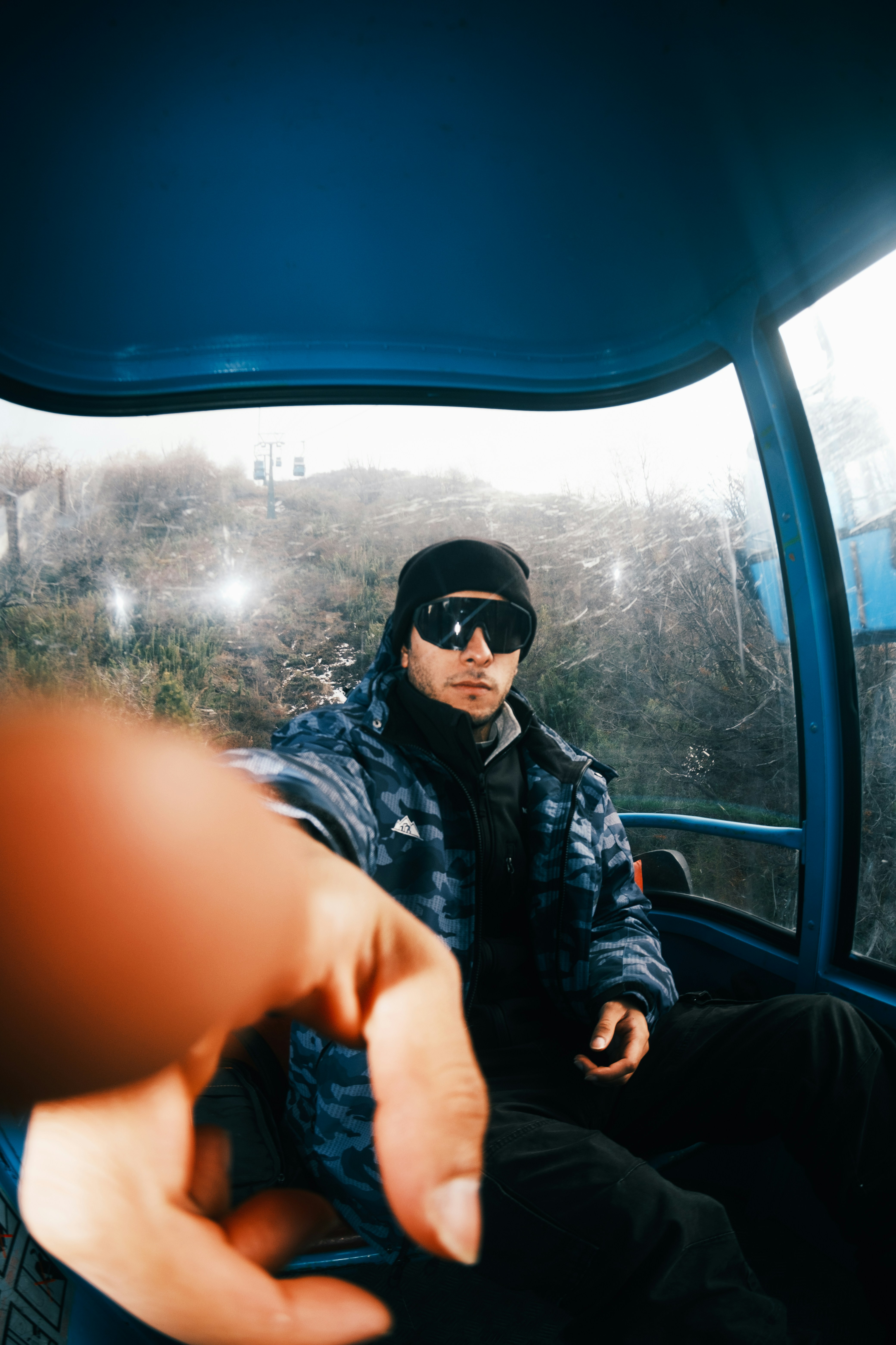 Man in winter gear riding a cable car.
