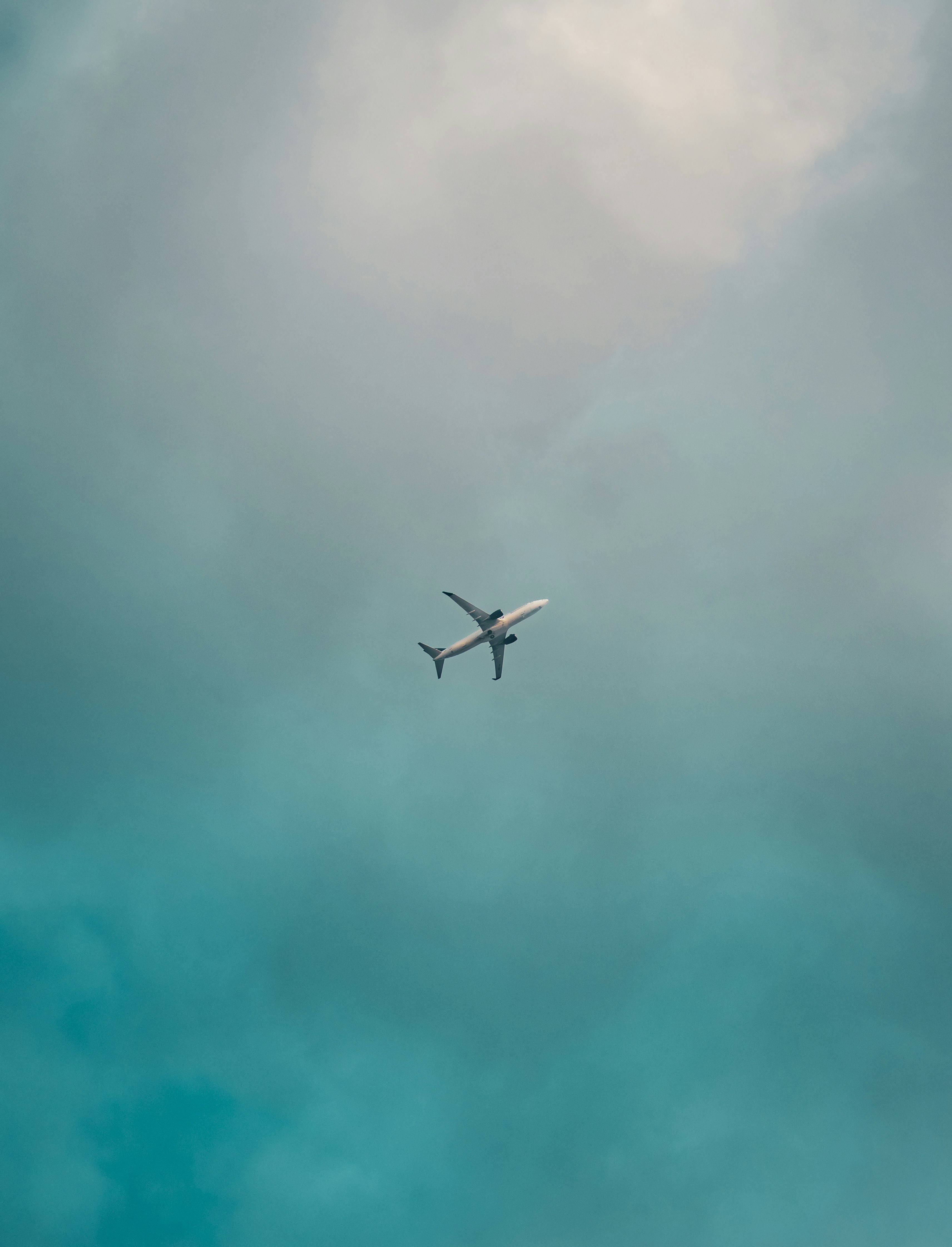 Silhouette of a jet mid-flight against a gradient blue sky with wispy clouds, emphasizing isolation and ascent; a clean, minimal aviation moment.