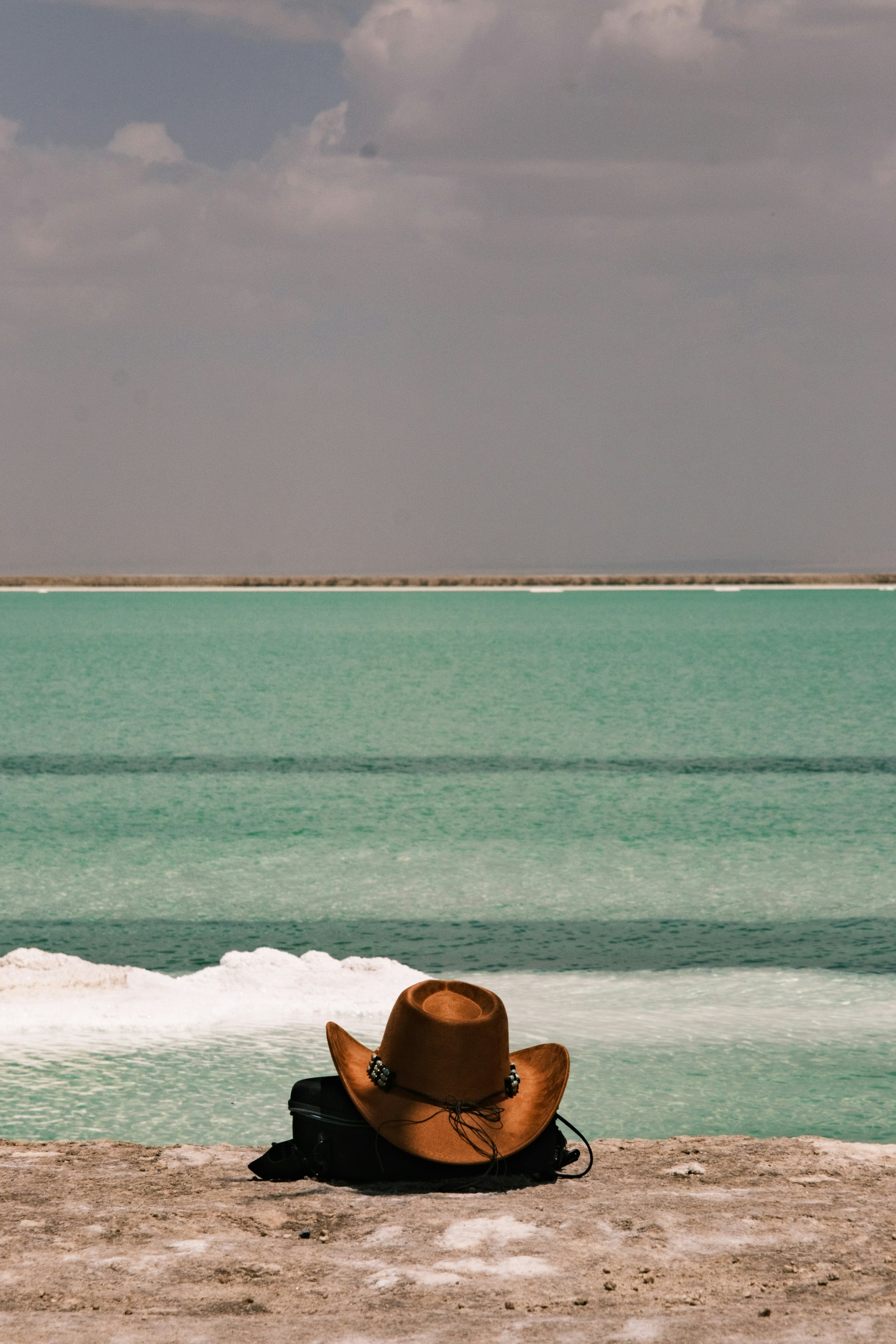 Deserted Hat by the Sea: A Quiet Moment on Turquoise Waters