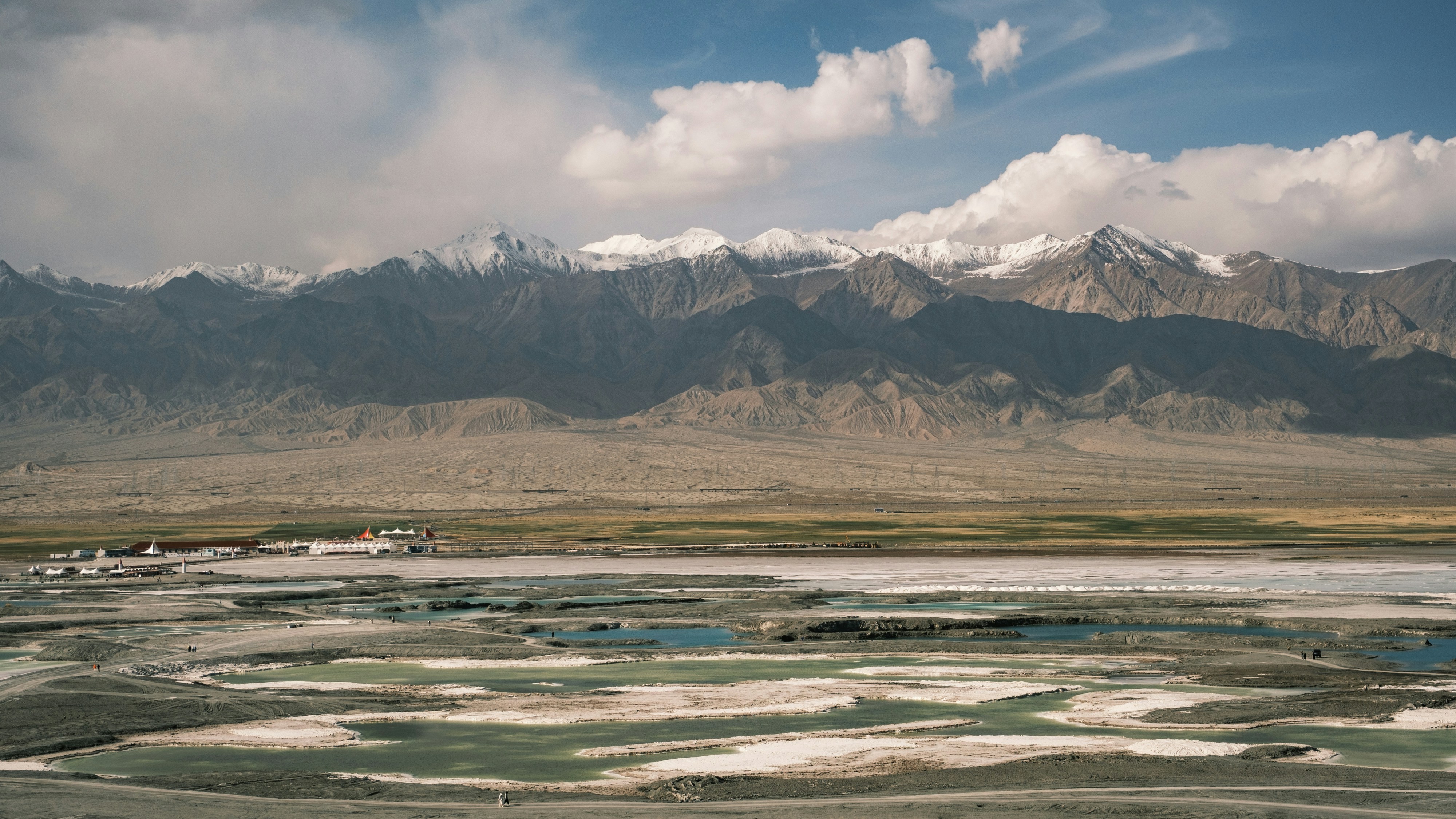 Snow‑kissed peaks over a mosaic of salt flats