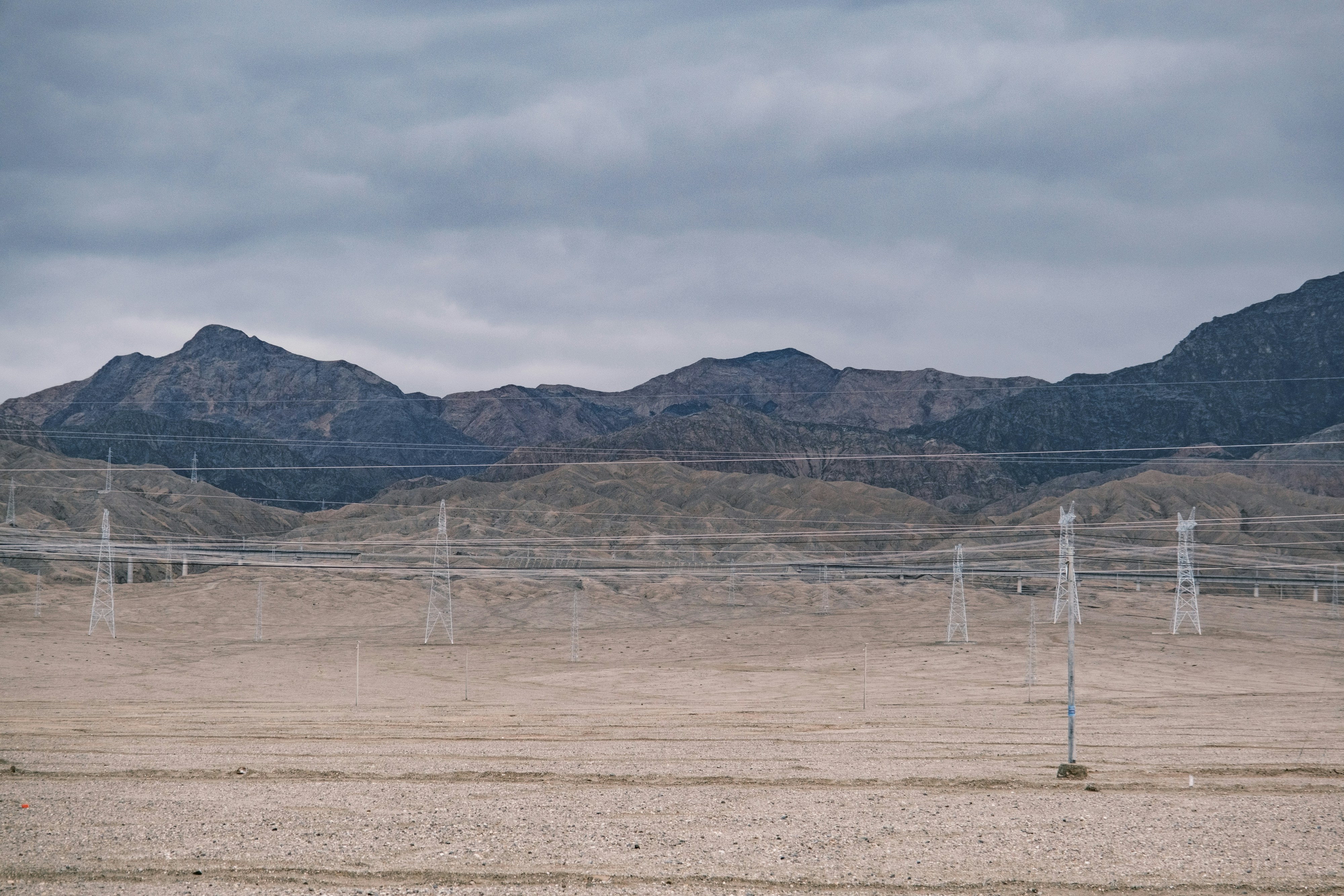Desert plain beneath a shale ridge with power lines
