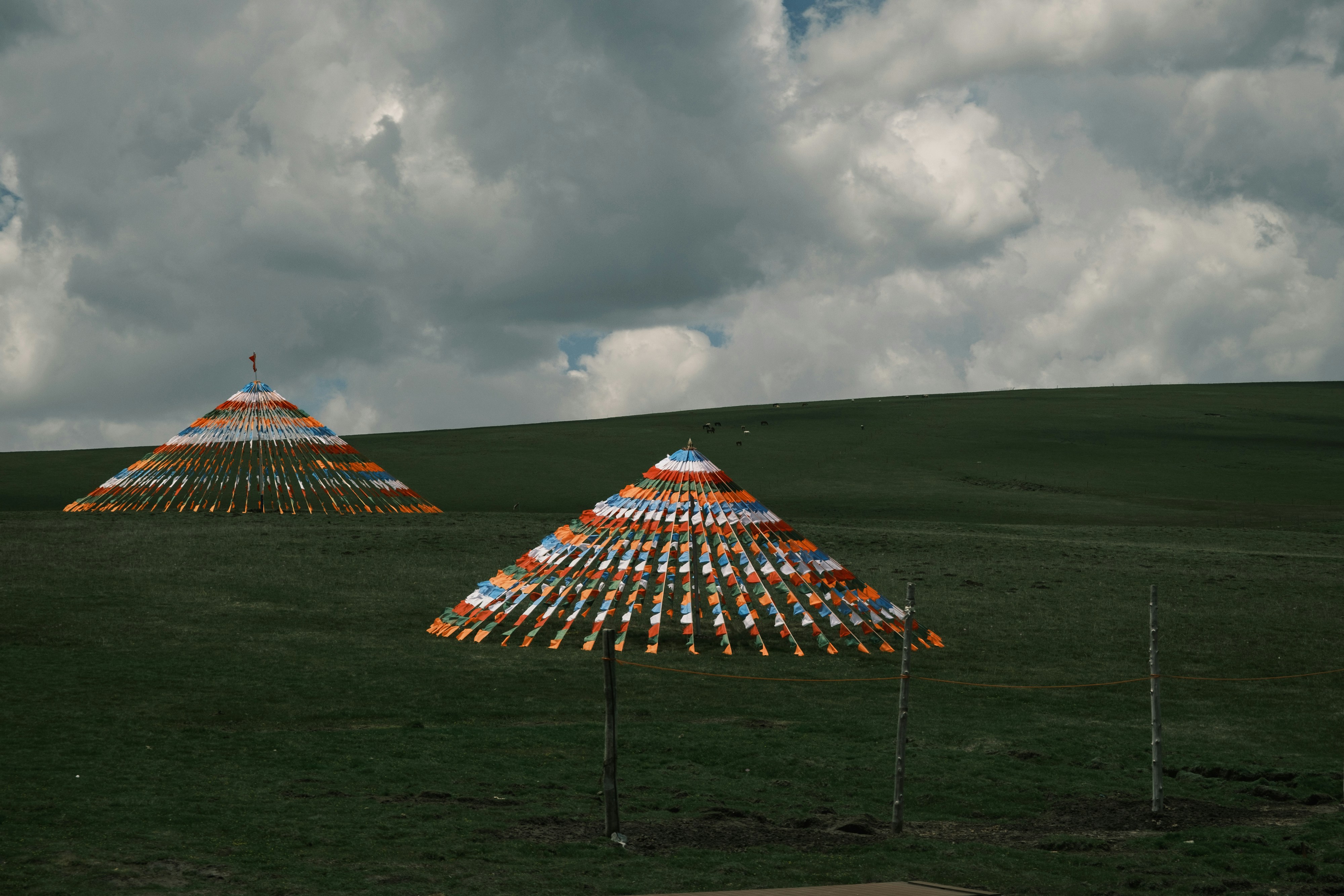 Two colorful flag pyramids on a green field.