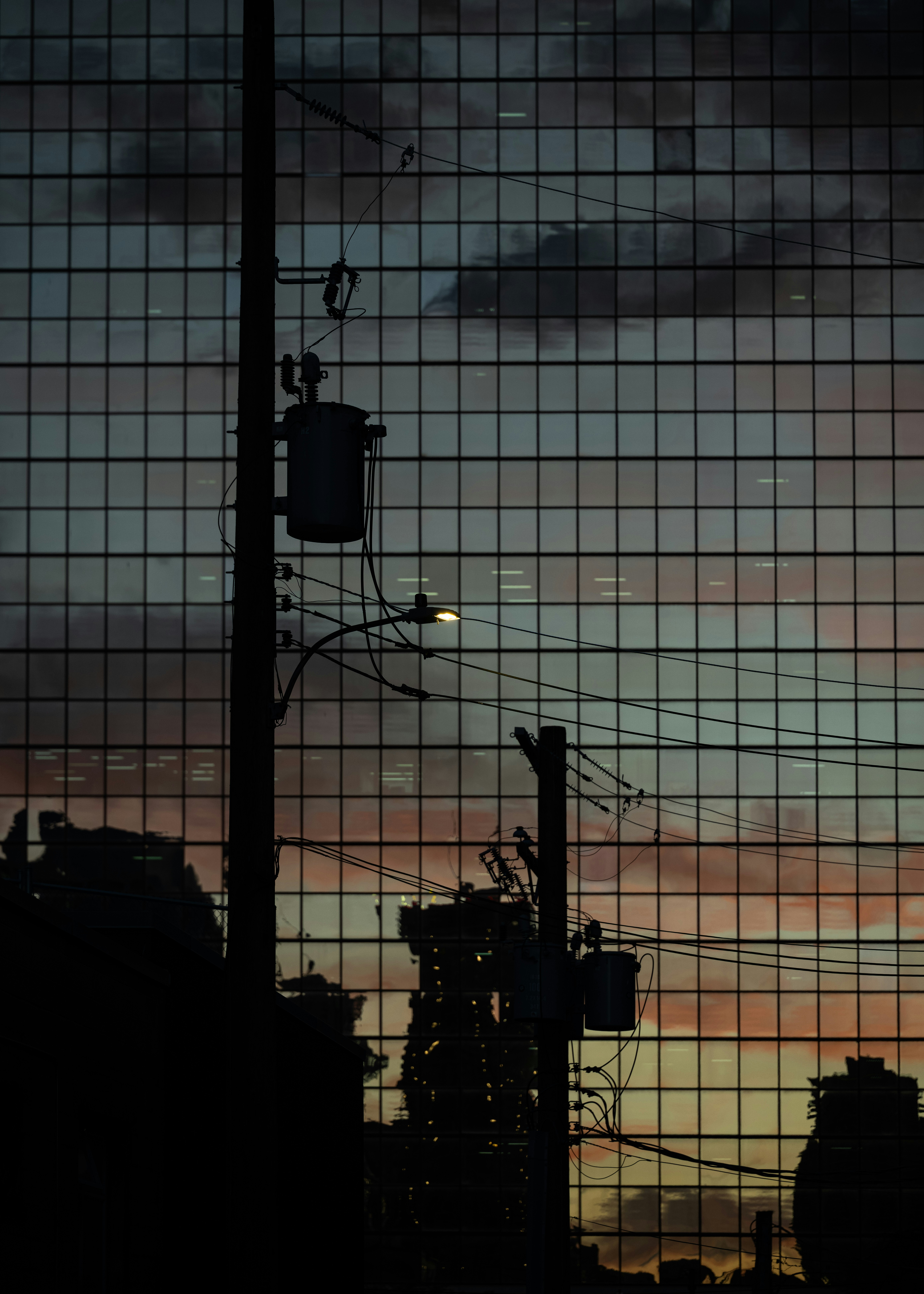 Grid of Dusk: Power Lines Amid a City Silhouette