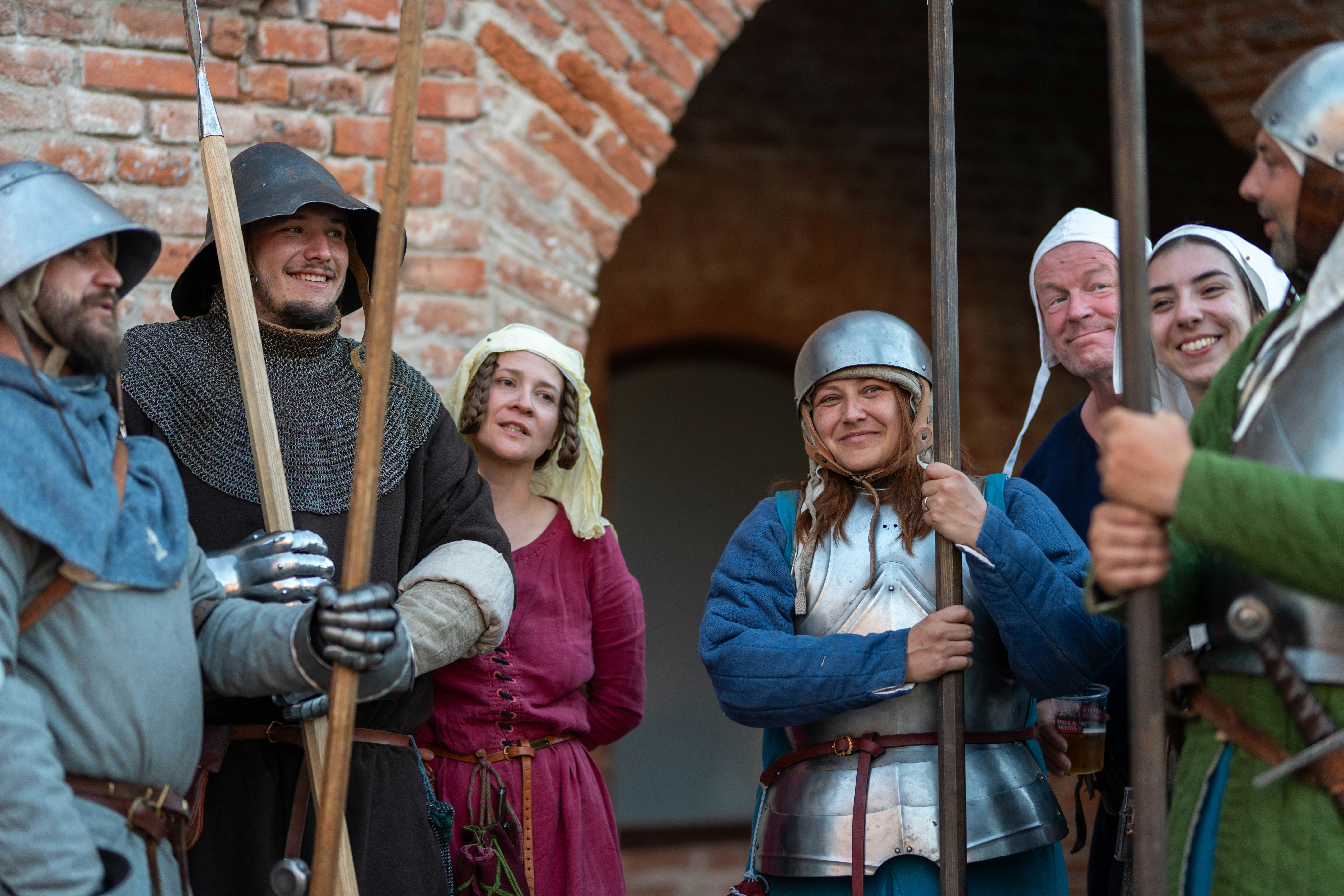 Medieval reenactors share a grin under archways