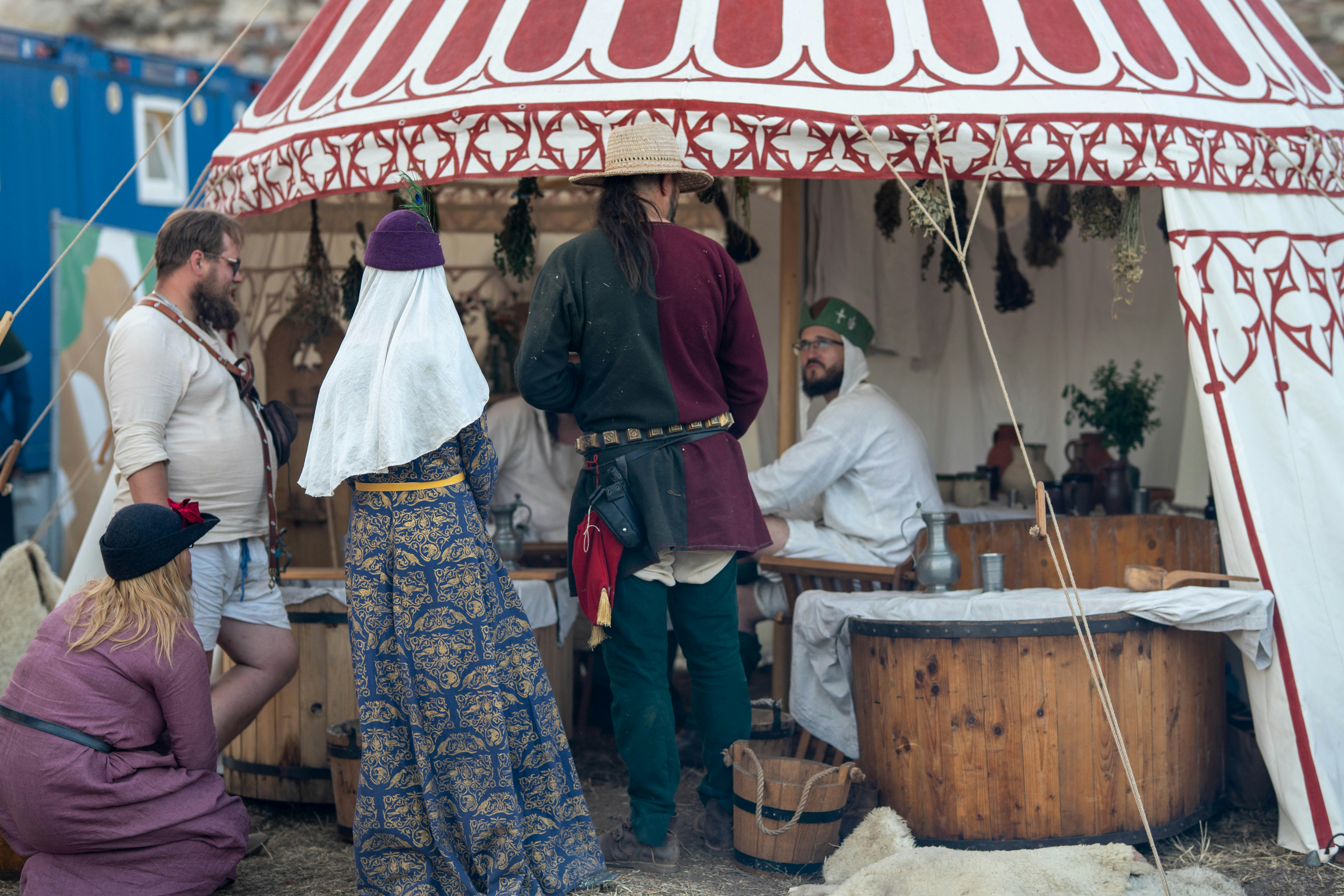 Medieval Market at Dusk: Cloaked Figures and a Producing Tent