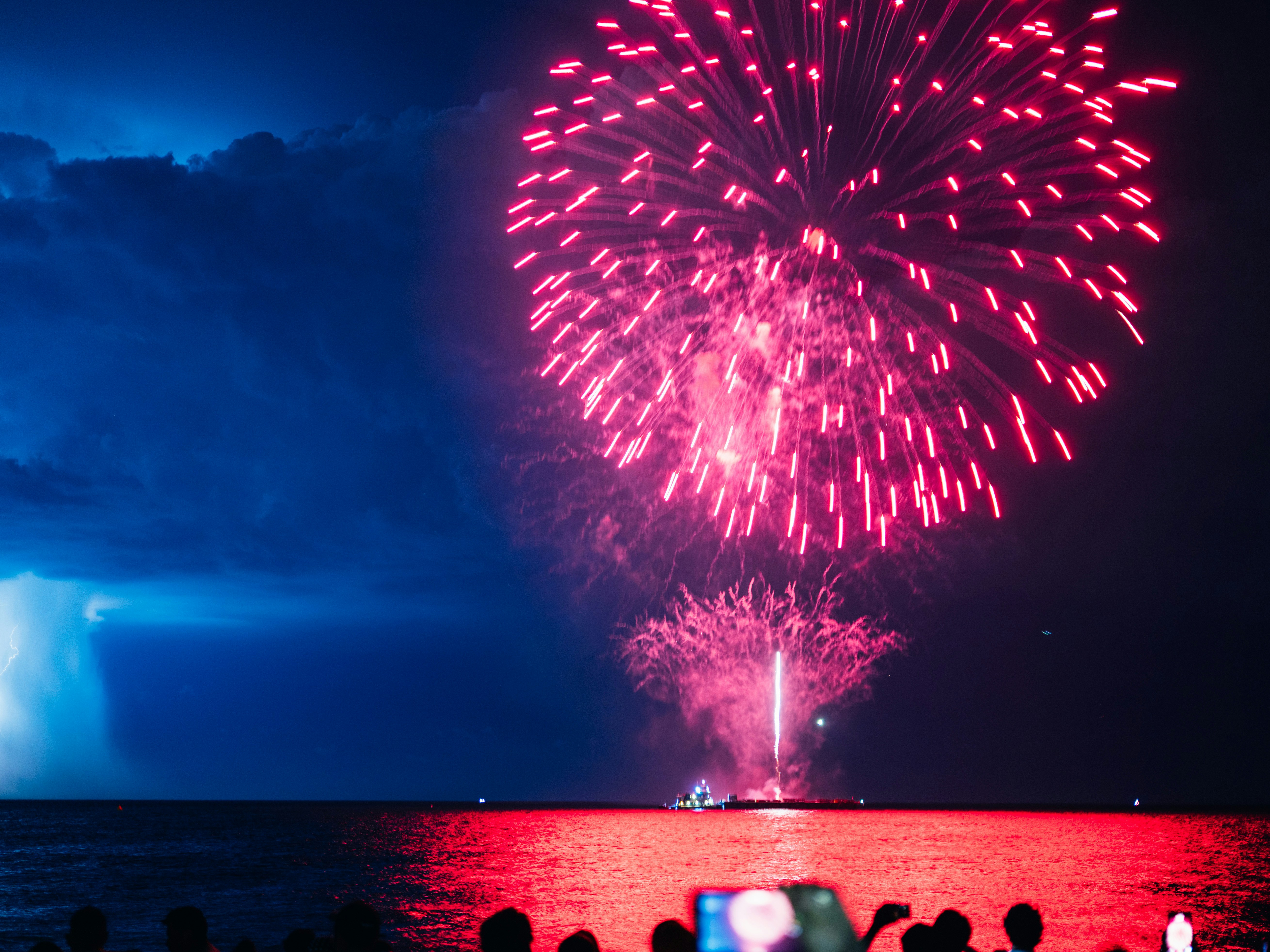 Red Aurora: Fireworks Over a Night Sea