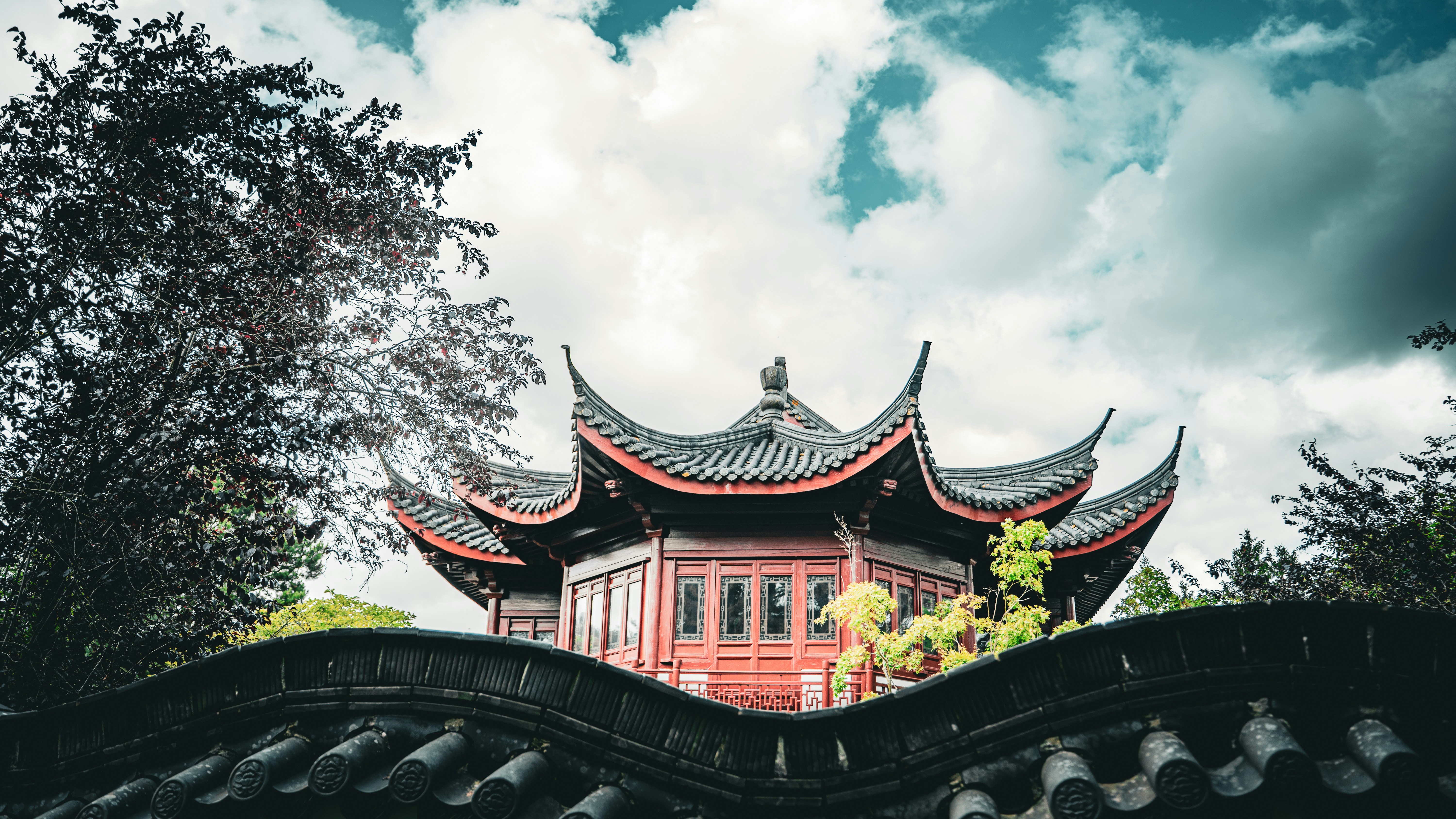 Red Pagoda Amid Curved Rooftops: A Quiet Temple Vista