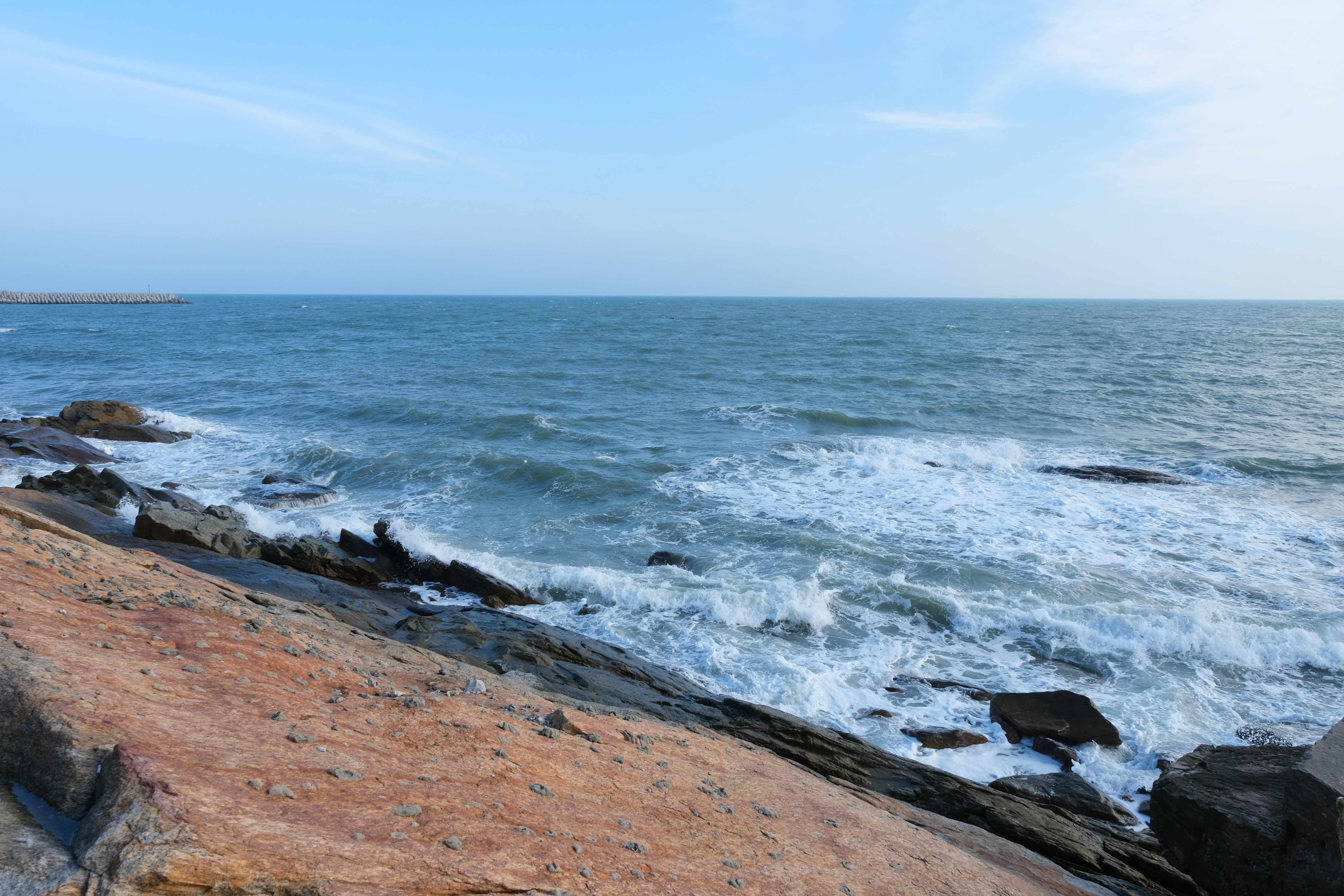 Coastal Granite: Waves Break Along Sloped Shore