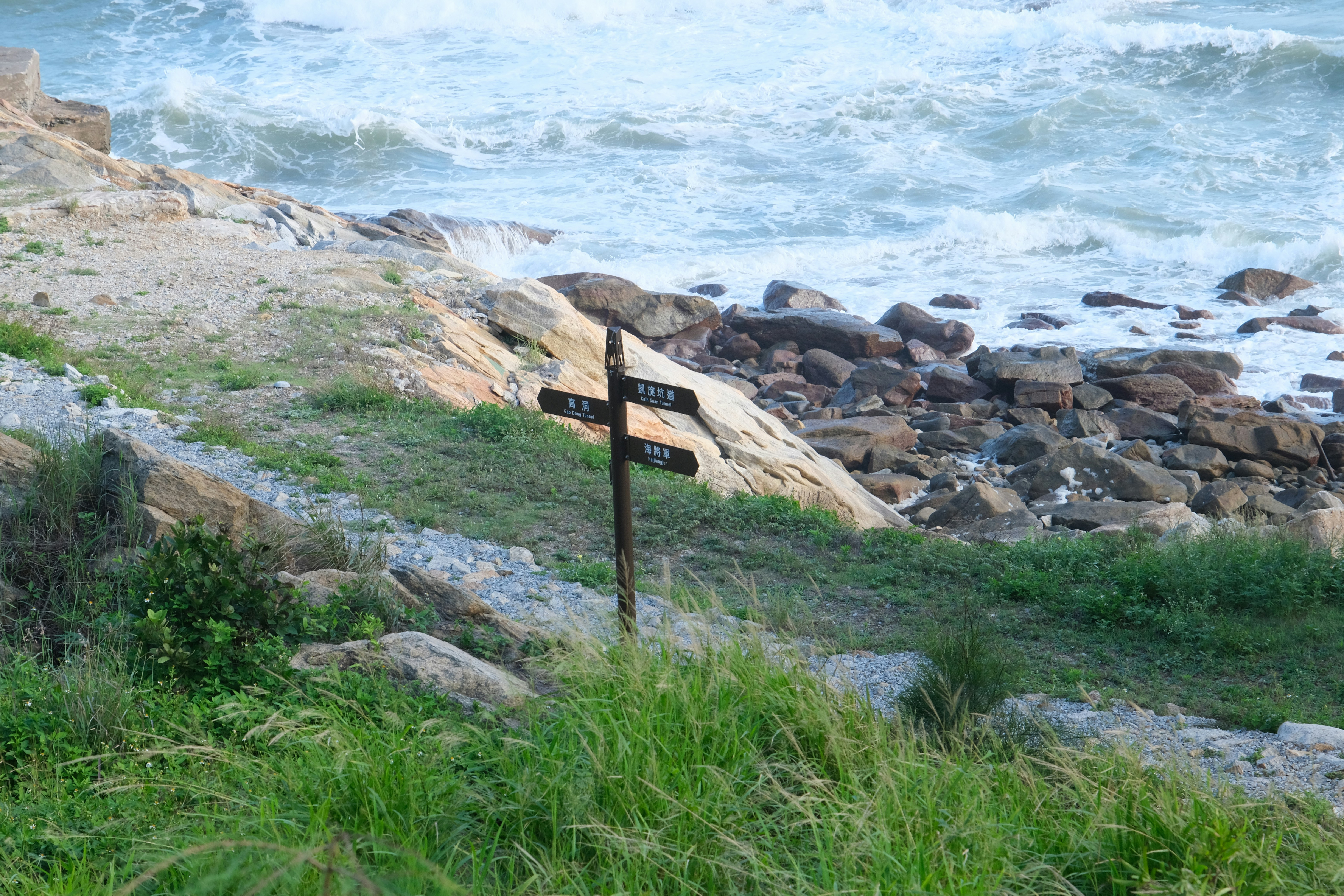 Trail Signpost by the Rocky Shore