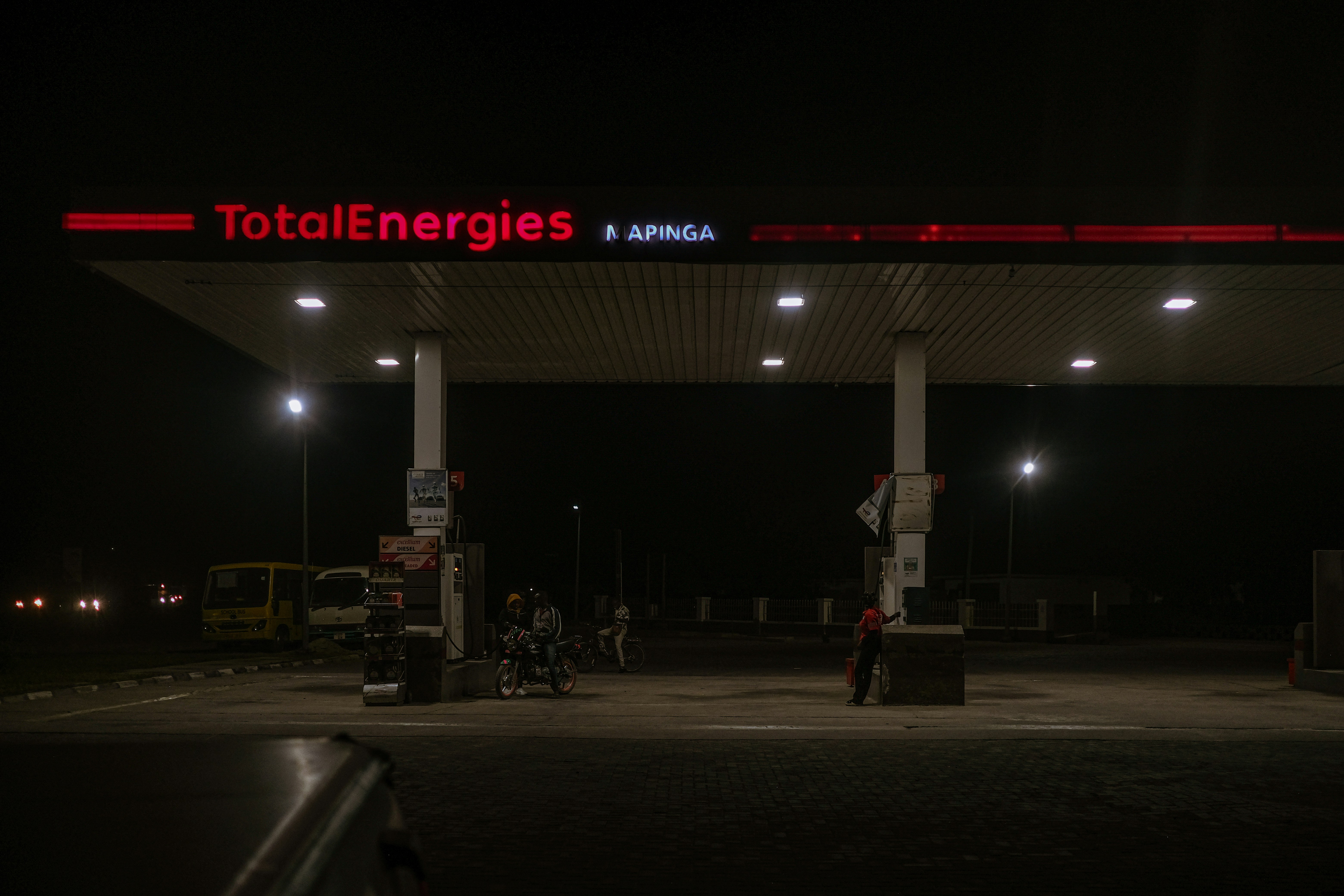 Night at the Quiet Pump: Neon Sign and Fuel Canopy
