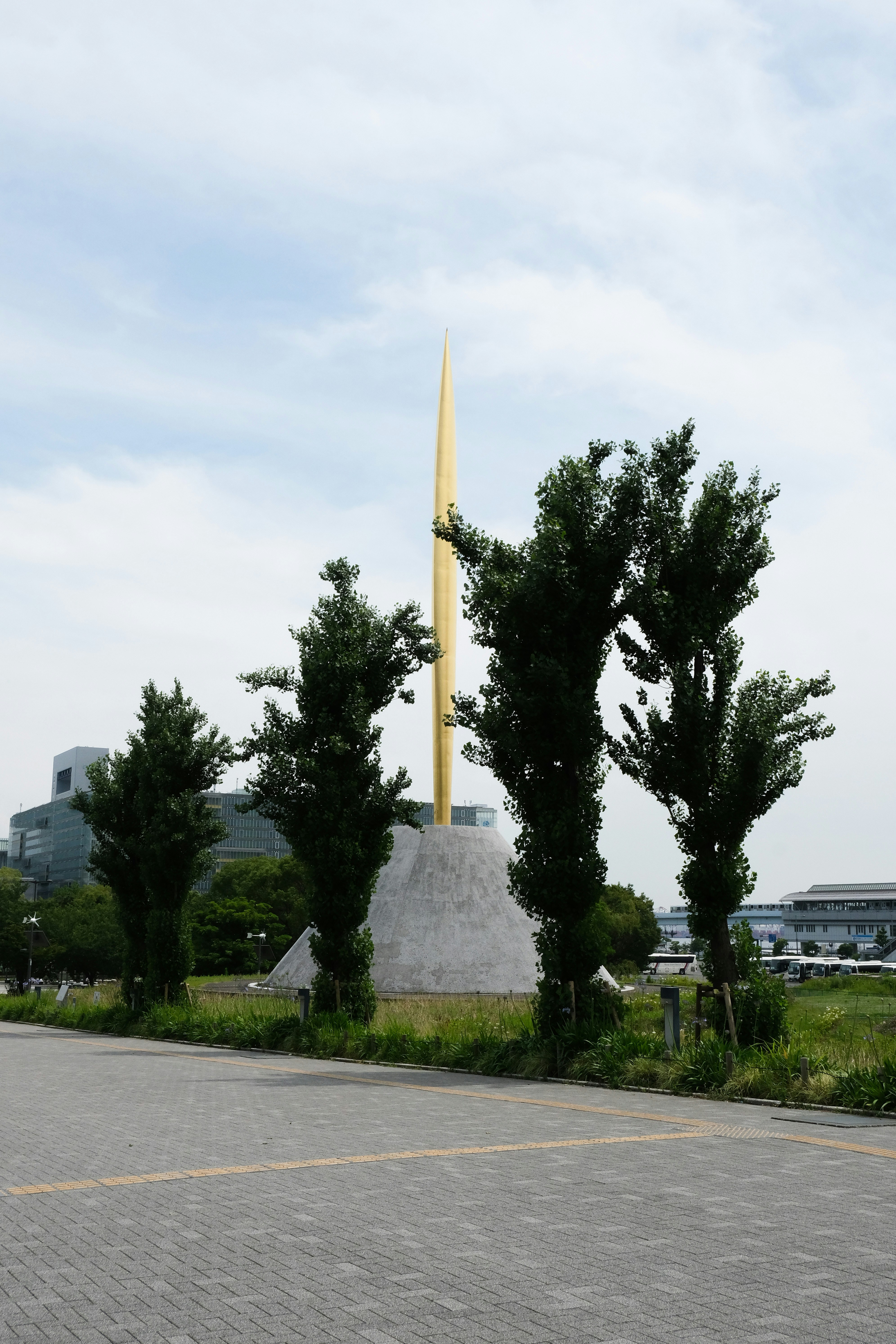 Gold Needle Reaching Skyward Amid Urban Greenery