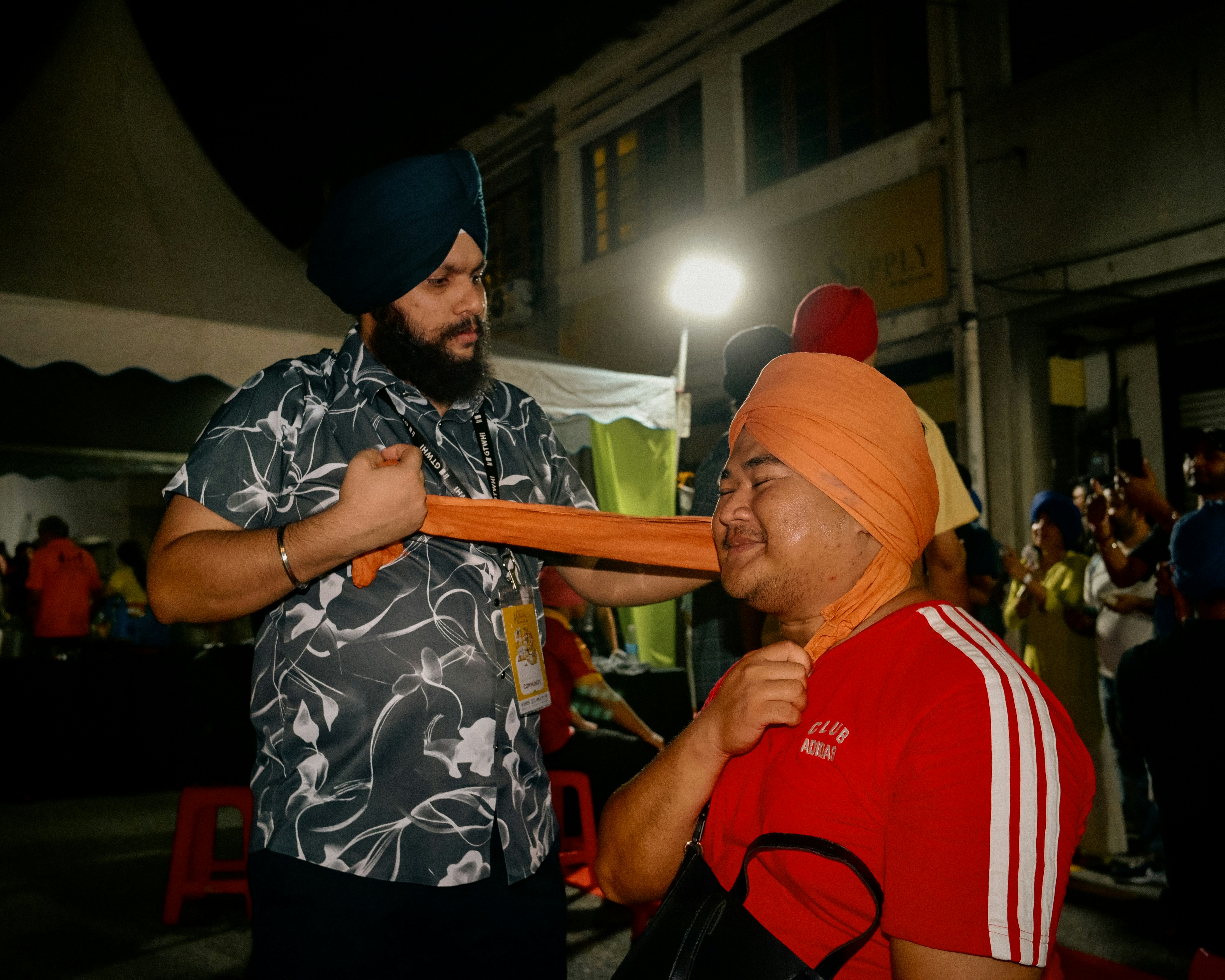 Turban Tug-of-Wriend: A Moment of Playful Roar at a Night Market