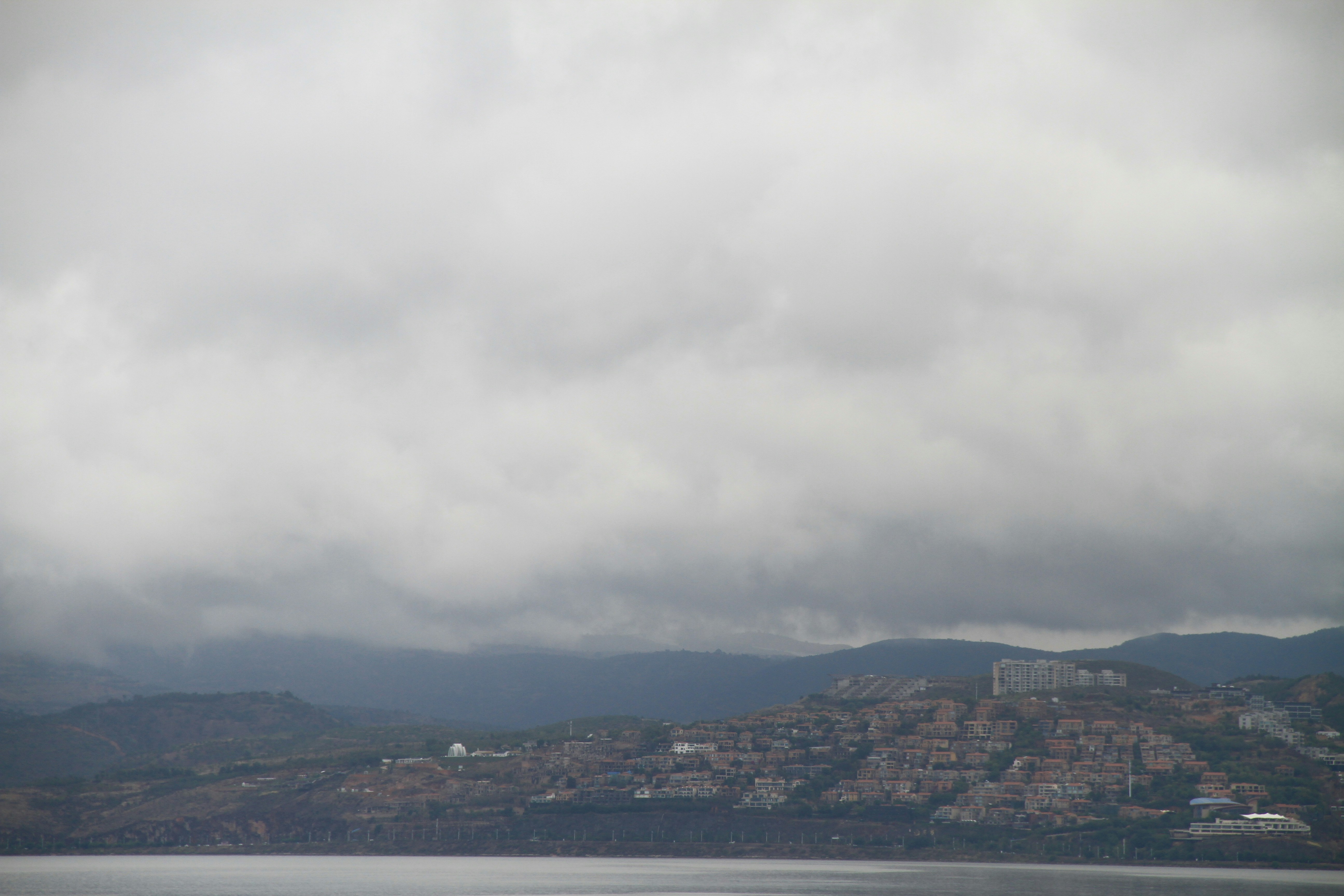 Coastal Town Beneath Layered Clouds