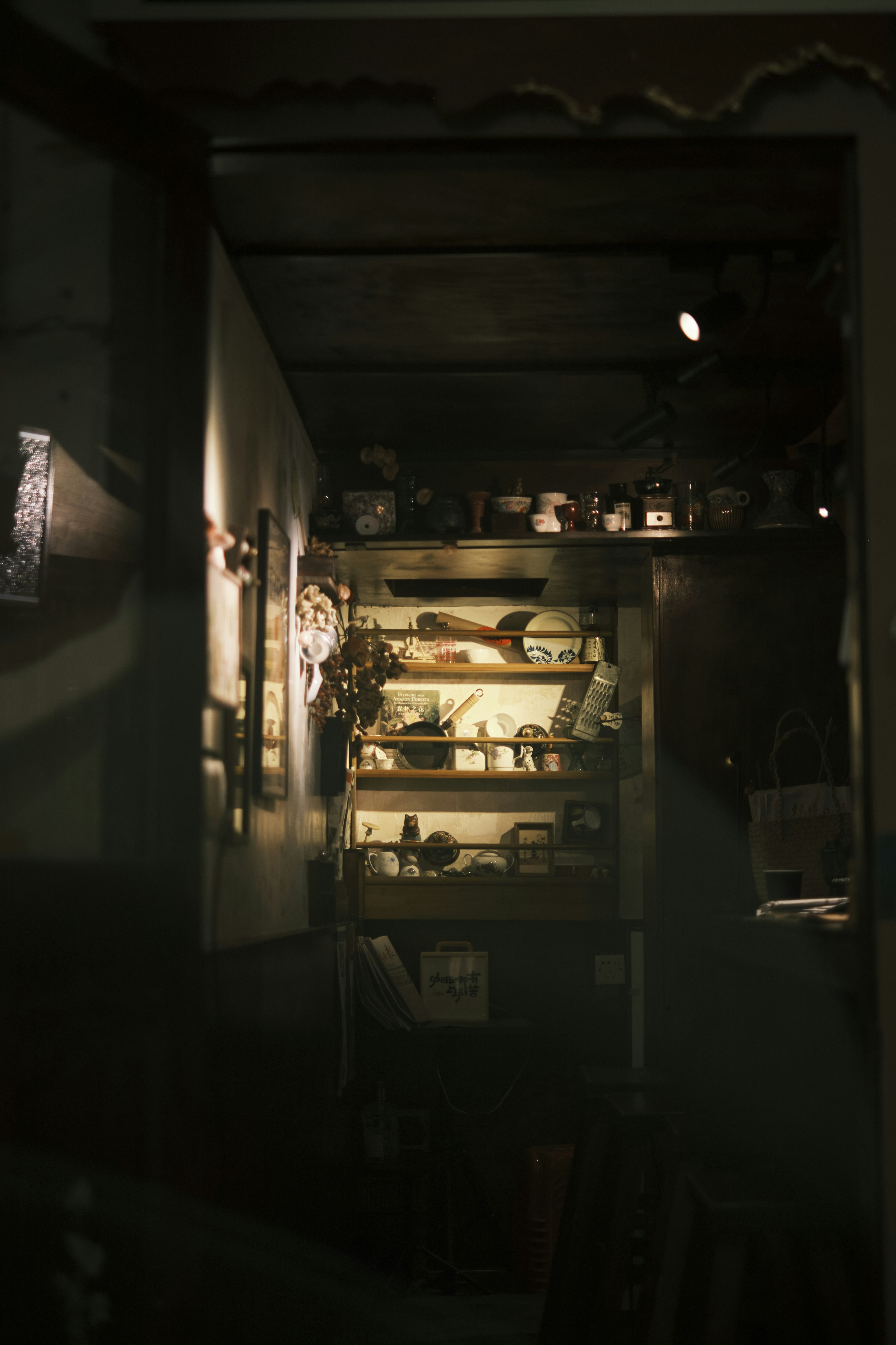 Sooty shelves and warm glow: a quiet corner of a cluttered shop