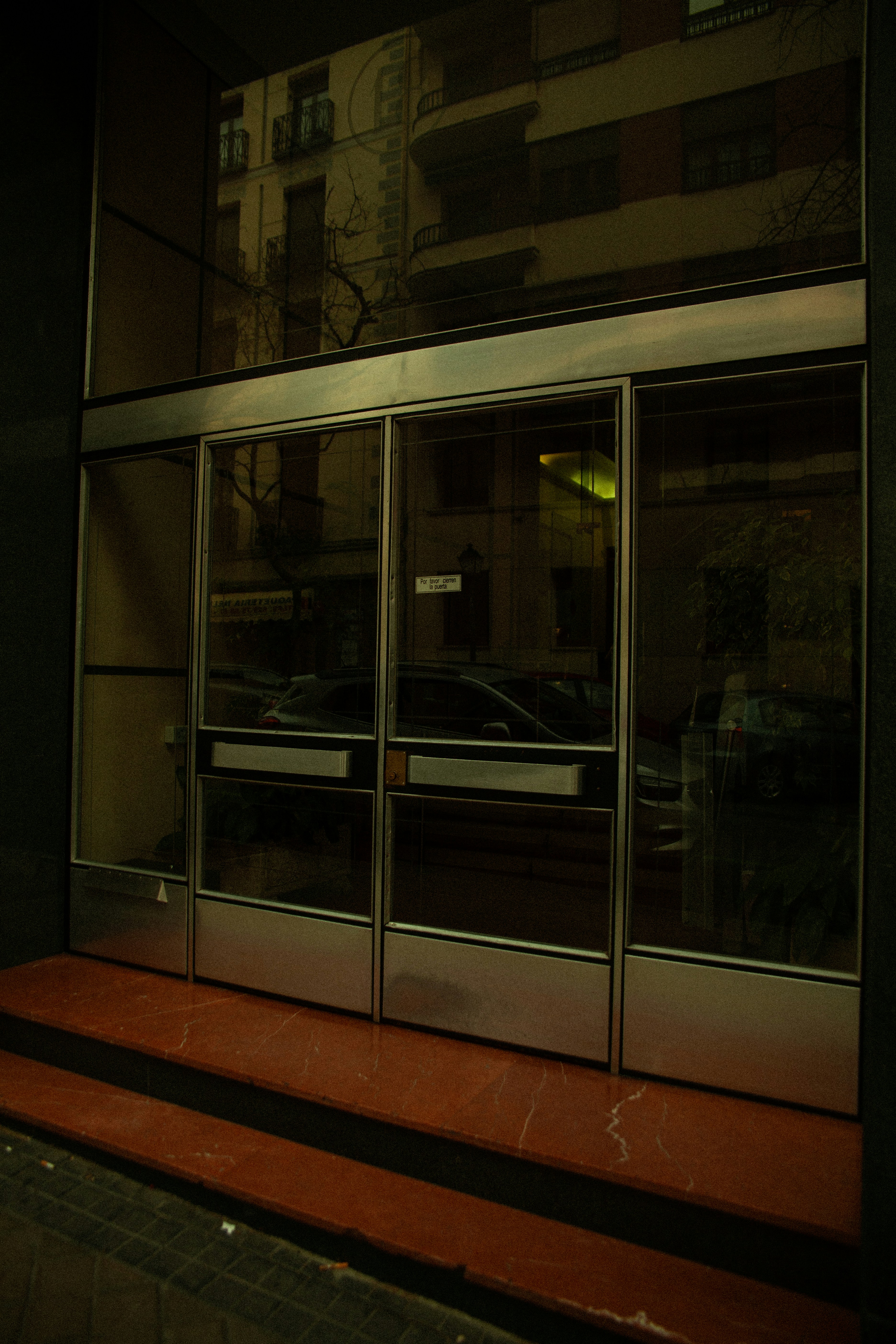Glass Doors at Dusk: Urban Entrance Reflected Facade