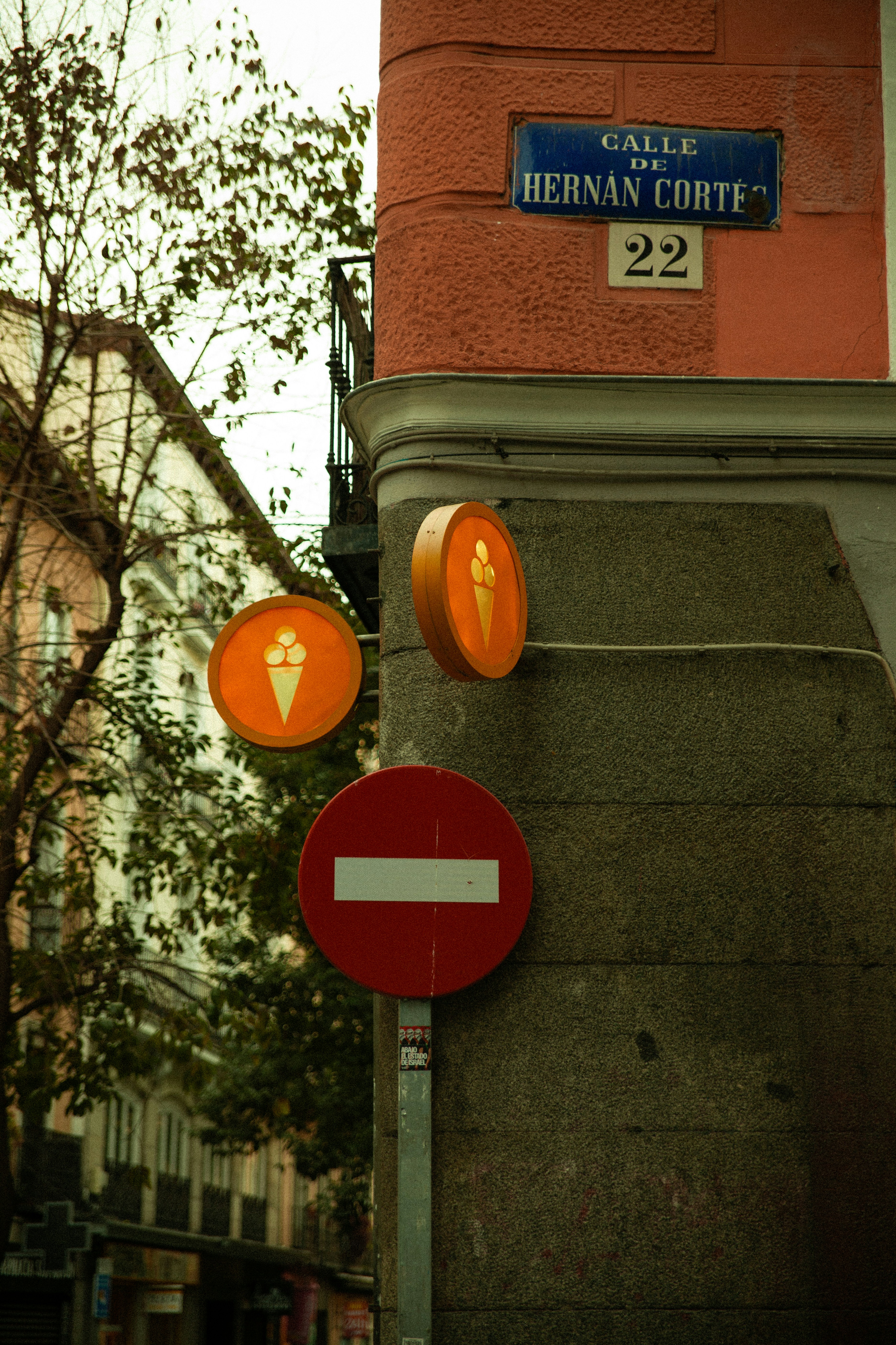 Orange signage On a Corner: Street Sign, Doorway Pillar, and No Entry Signal