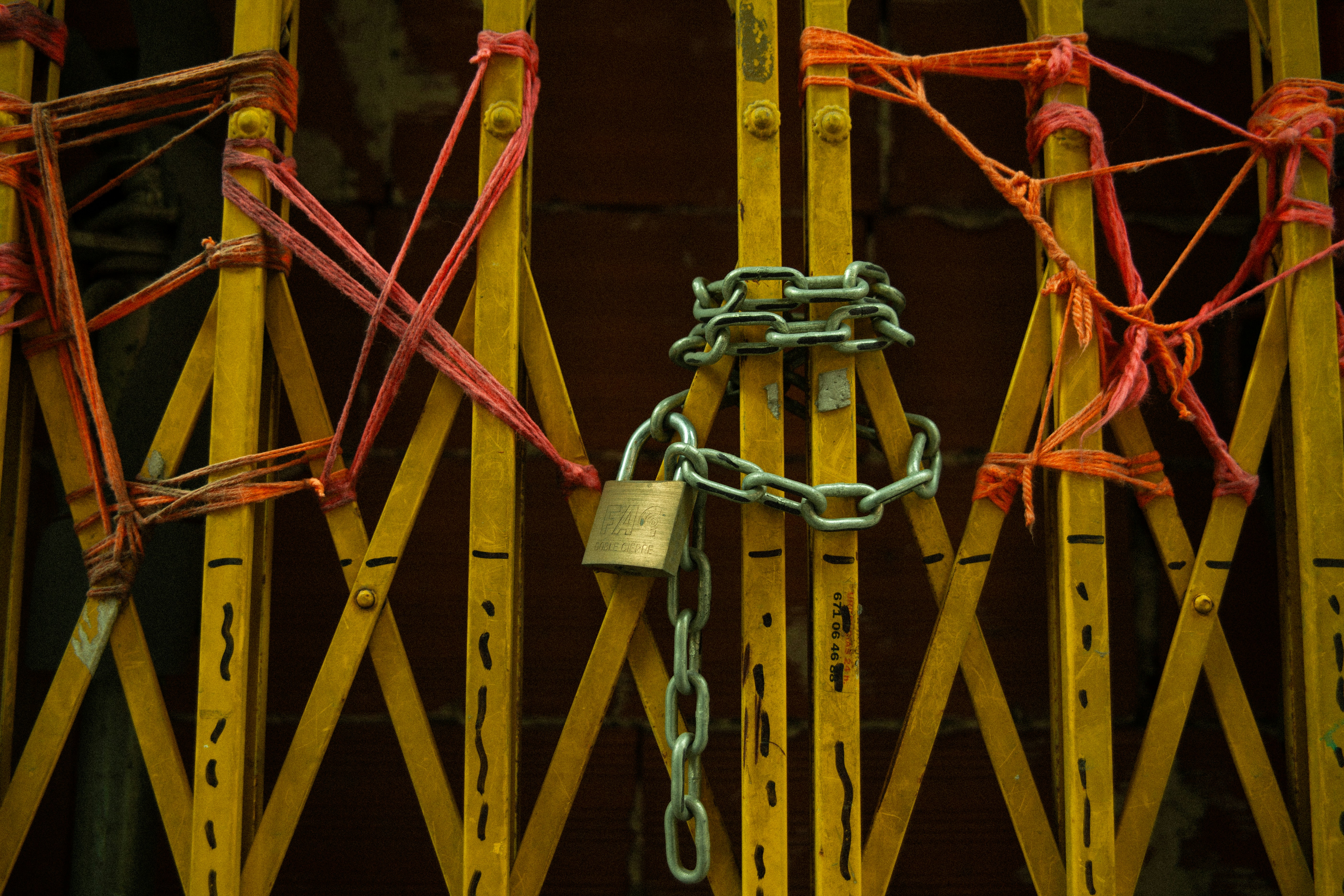 Locked in Place: Chains and Straps on Yellow Metal Frames