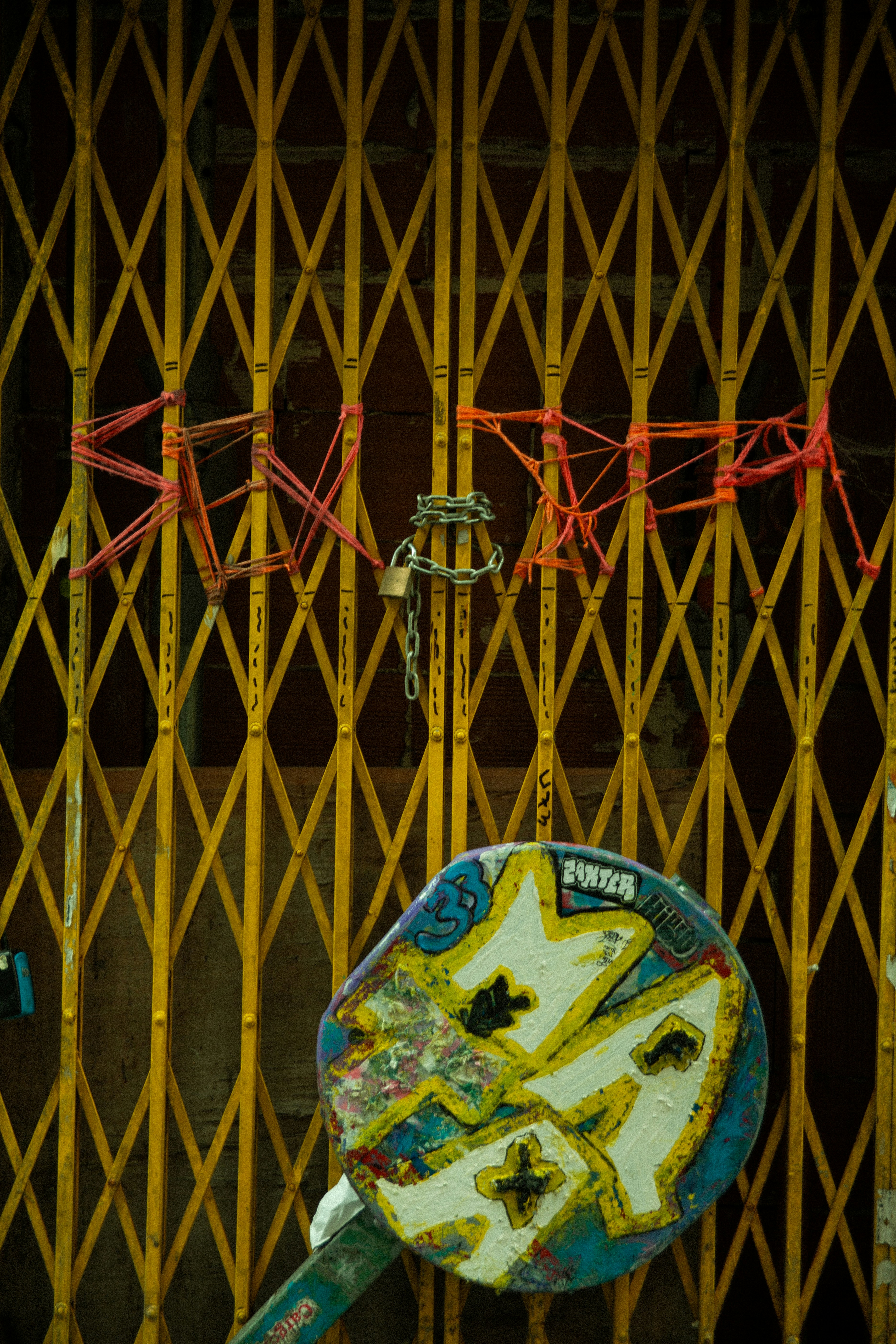 Locked Gate, Painted Shield: Urban Decay Behind Yellow Bars