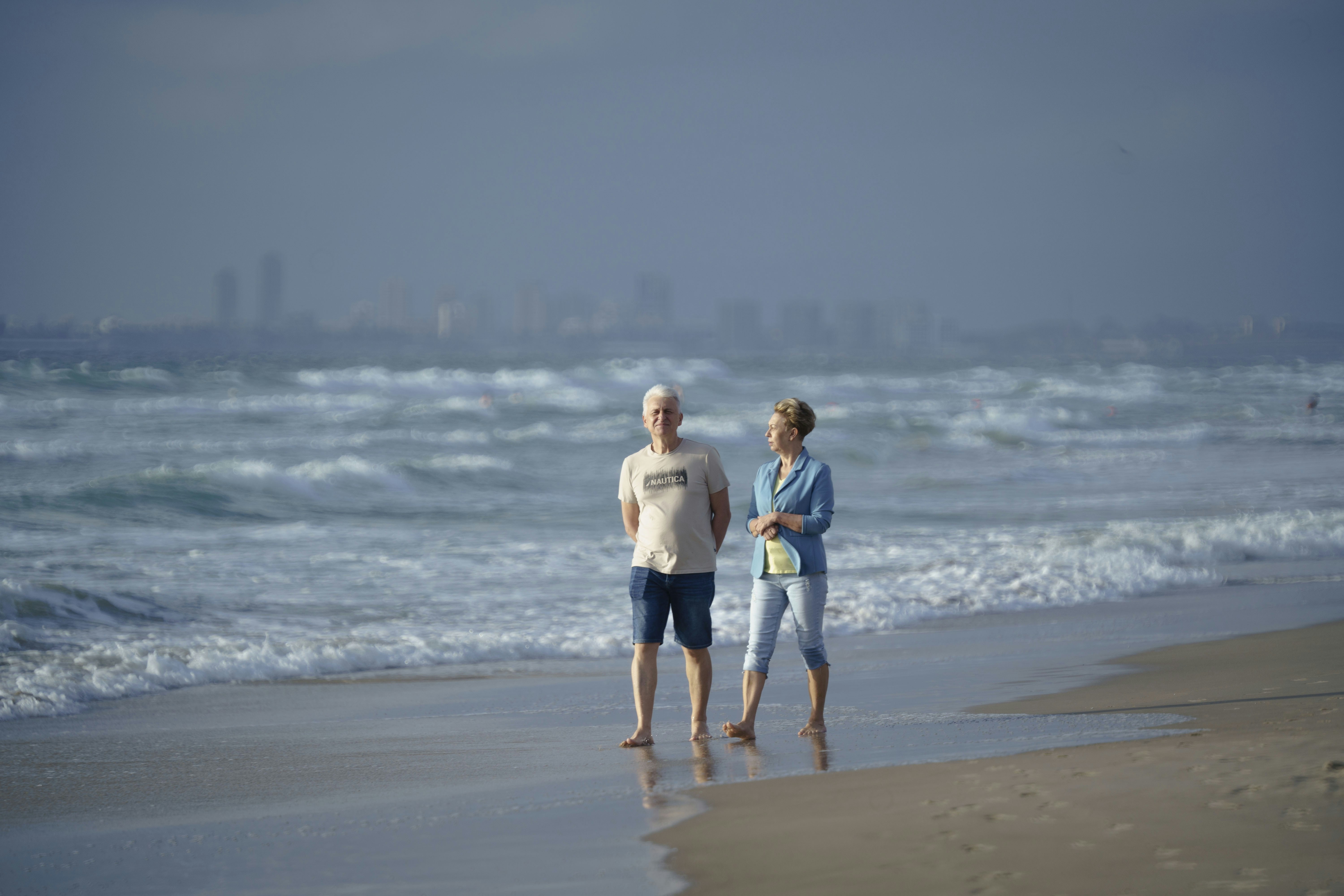Two Beachwalkers in a Quiet Tide with Distant Skyline