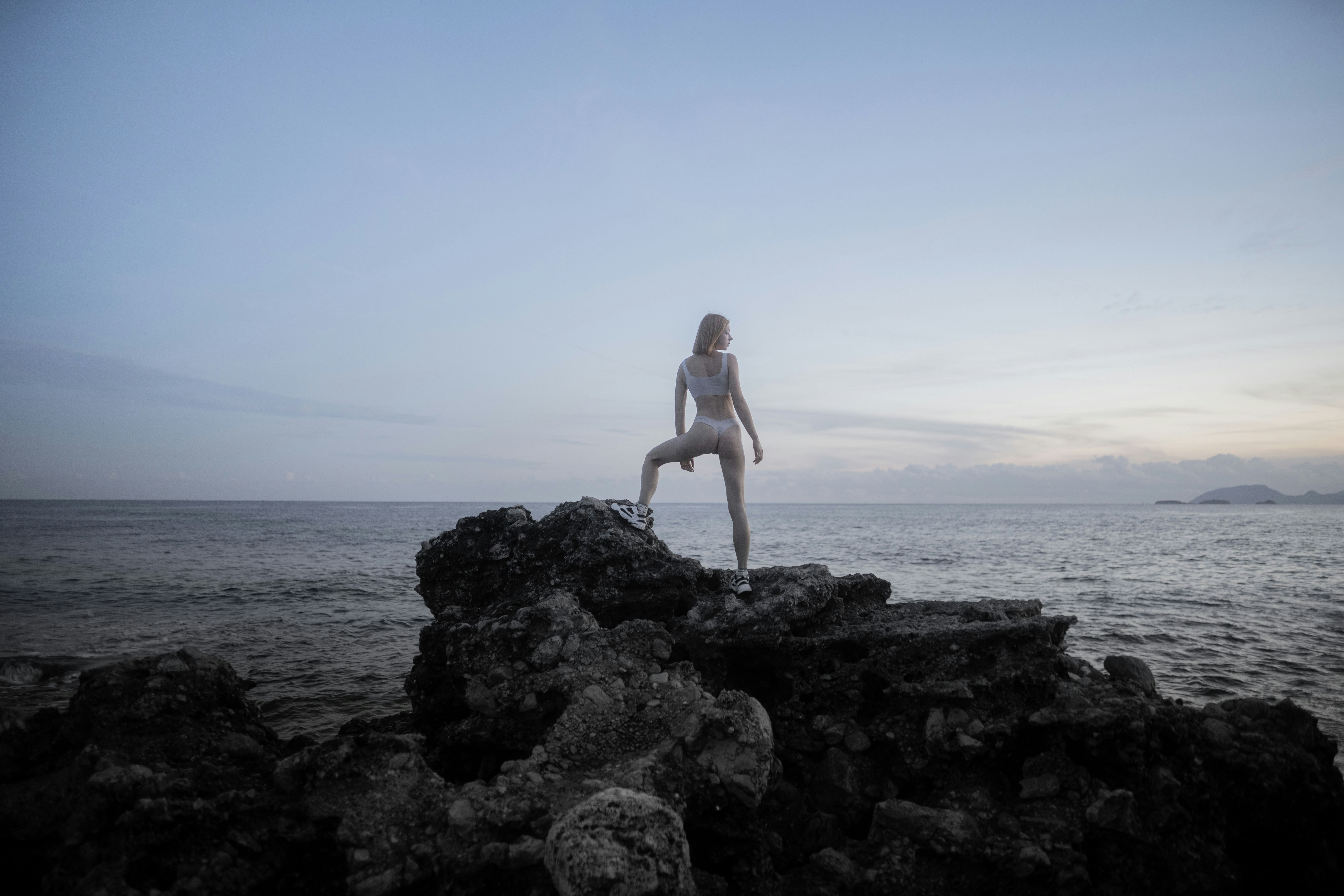Lone Figure Reaching for Horizon from the Jagged Sea Cliffs
