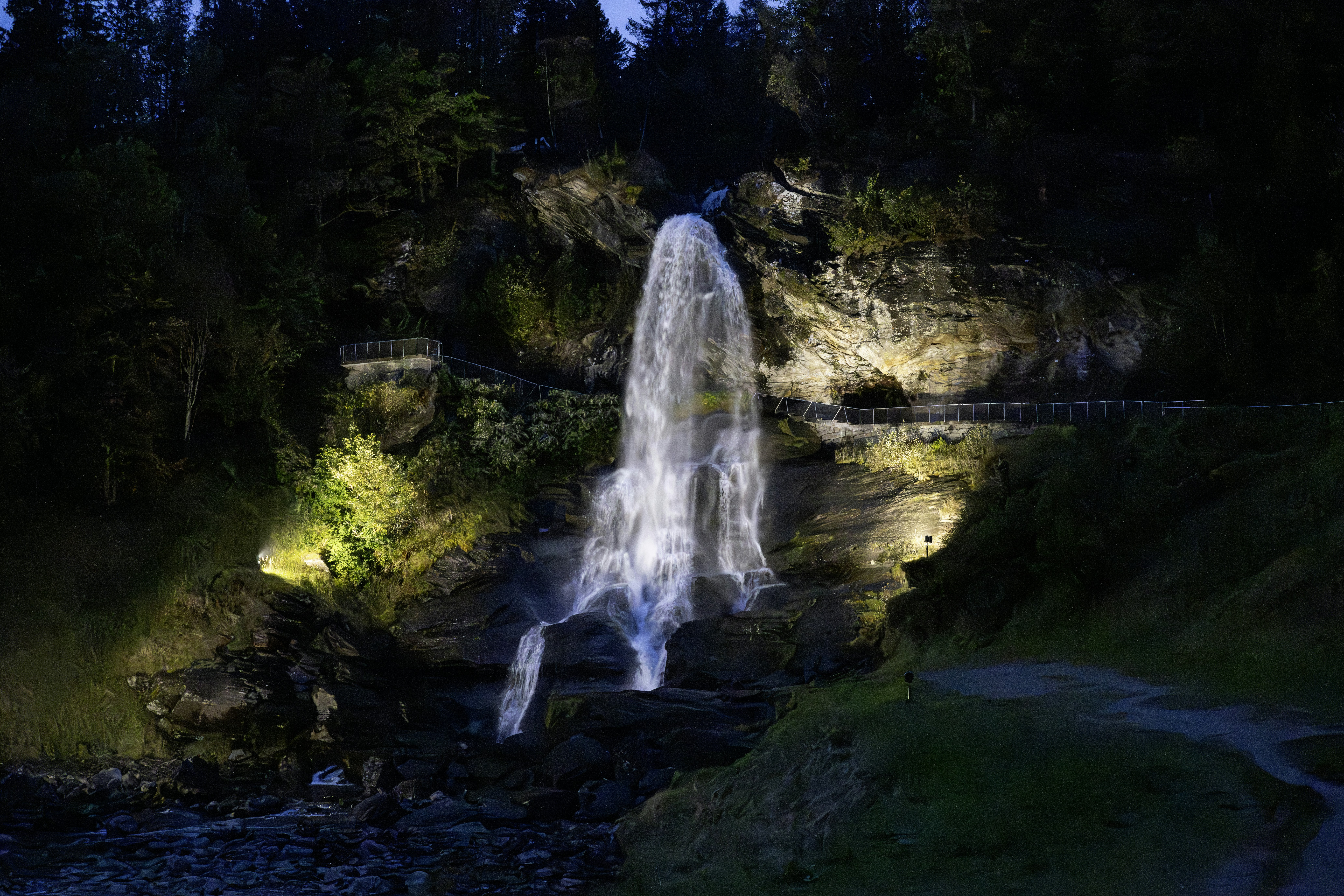 Cascade under the Bridge: Nighttime Glow on a Forest Waterfall
