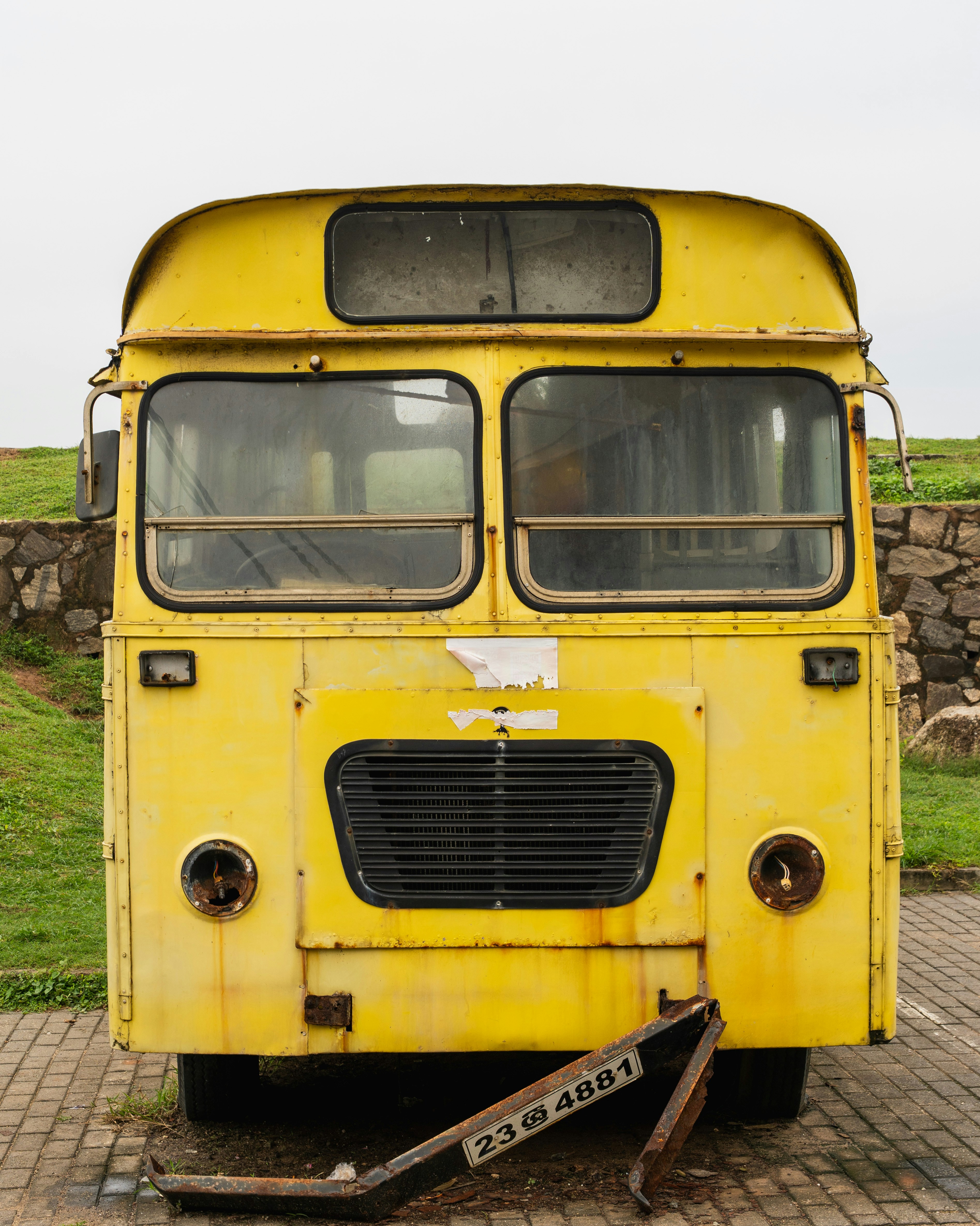 Yellow Retro Bus Faces the Camera: A Weathered Sleeper of Stone and Rails