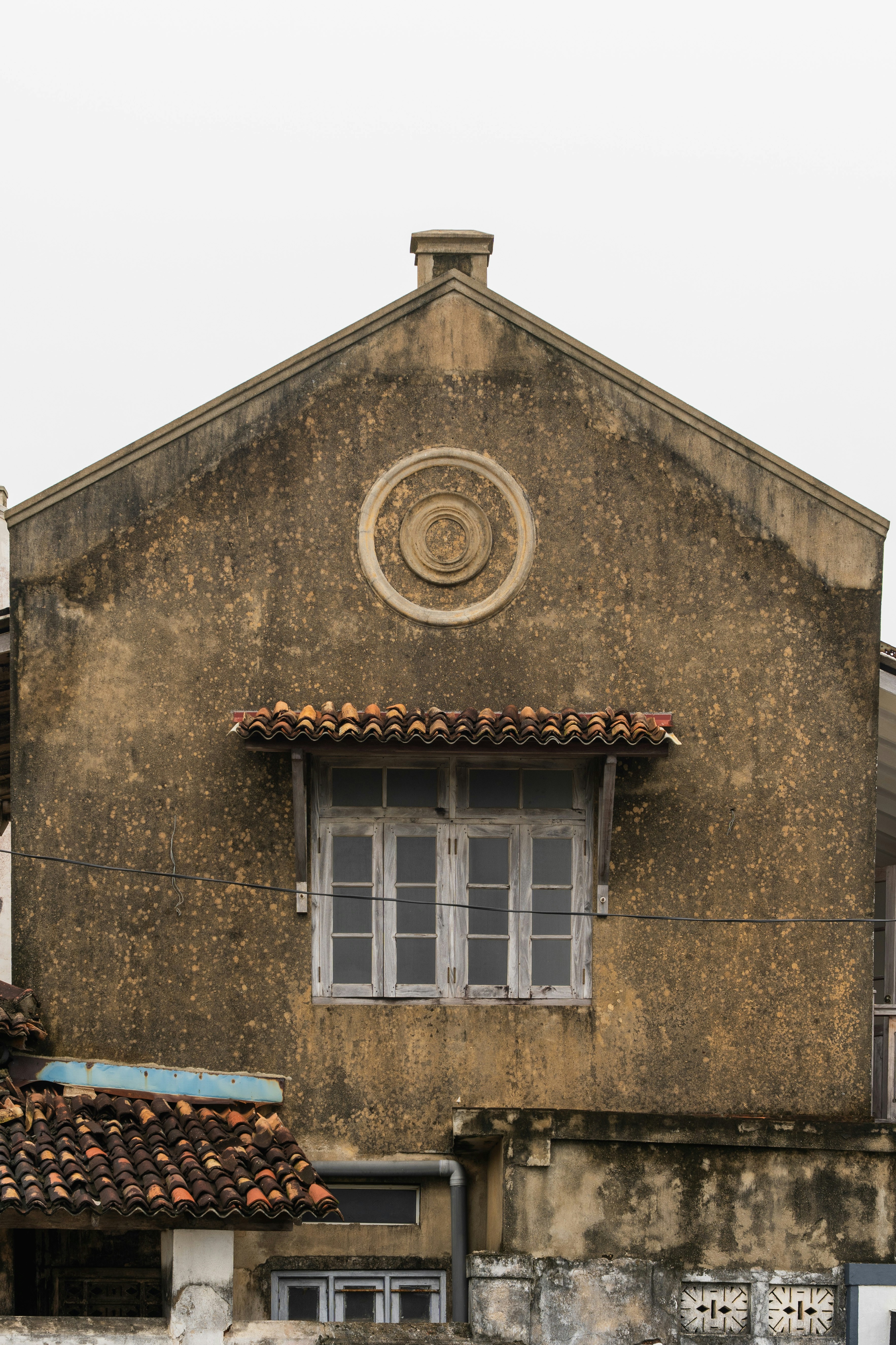 Weathered Facade Horizon: A Gable Crown Over Tiled Ancestry