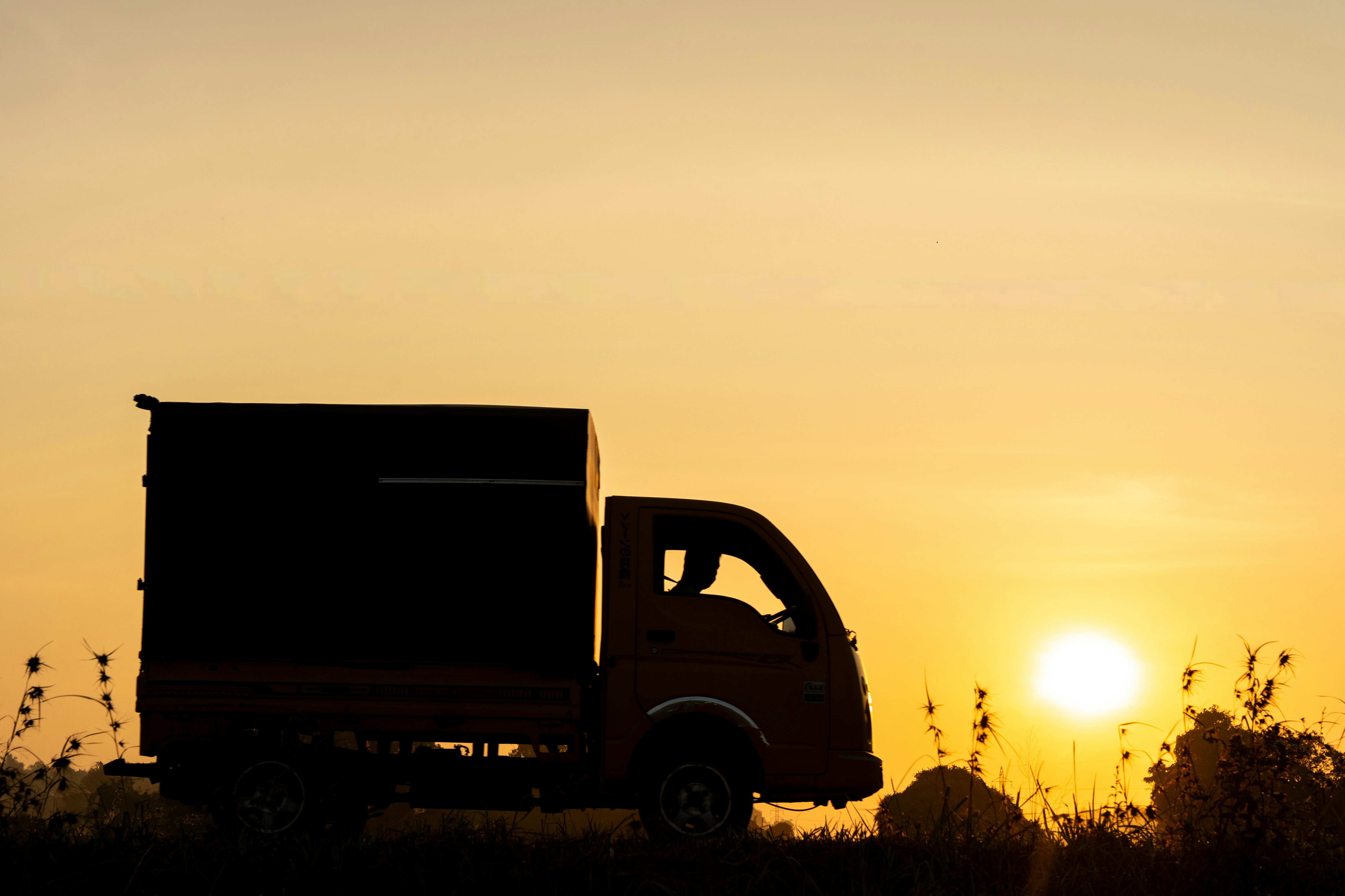 Silhouette of a Truck at Sunset Over a Quiet Landscape