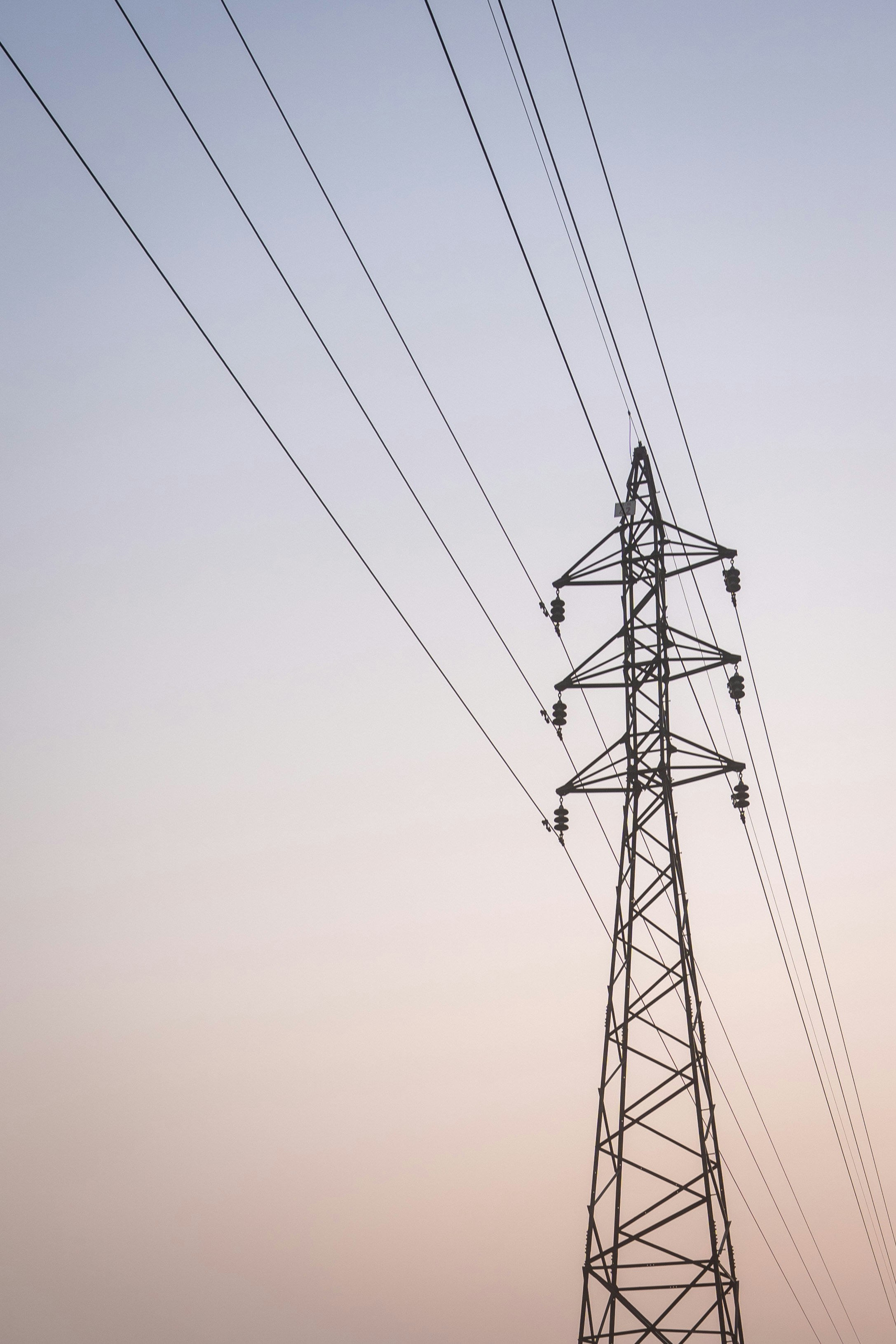 Commanding Lines: A Transmission Tower Reaches into a Gradient Sky