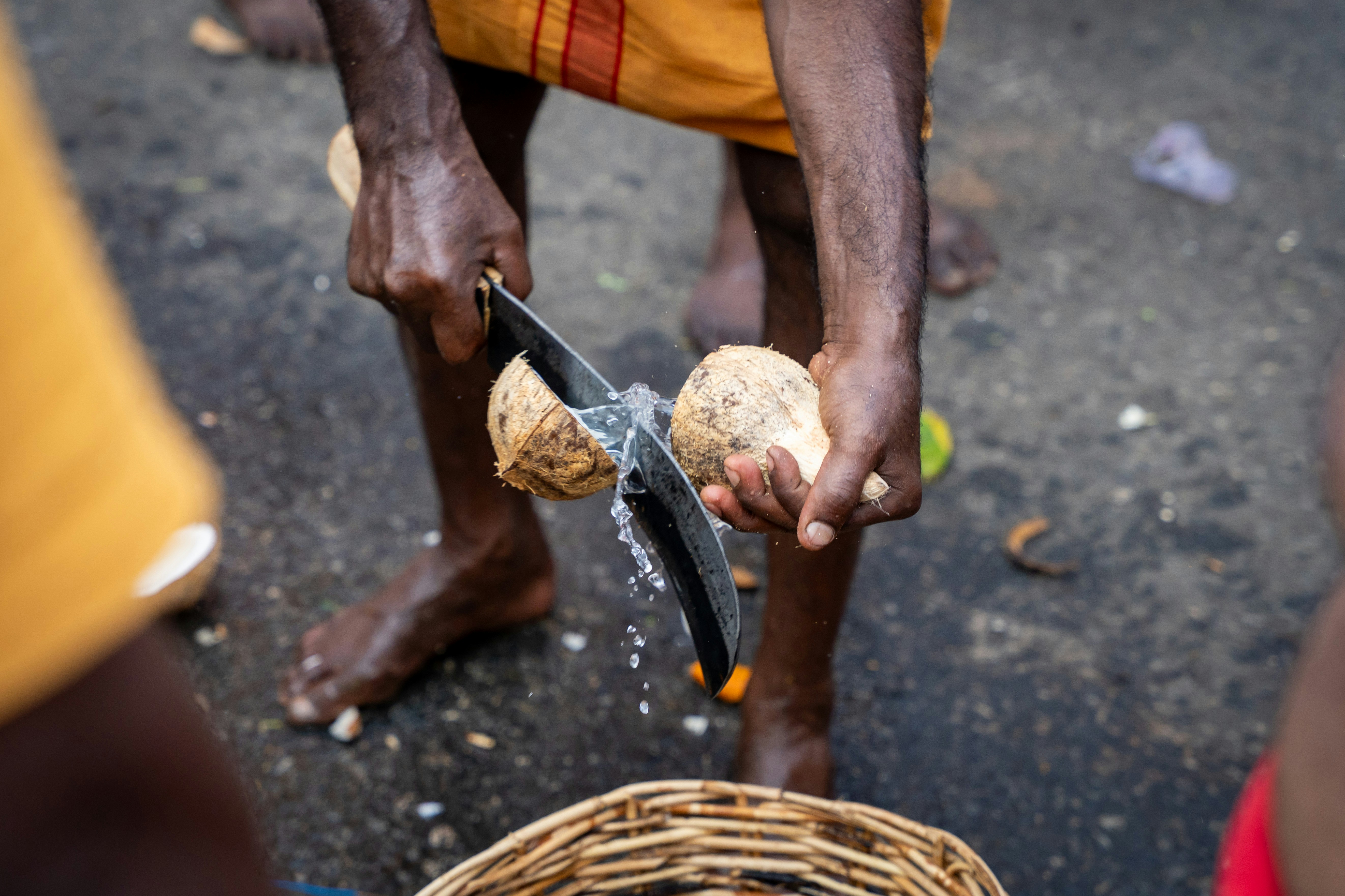 Cutting fresh bread fruit in a sunlit street market