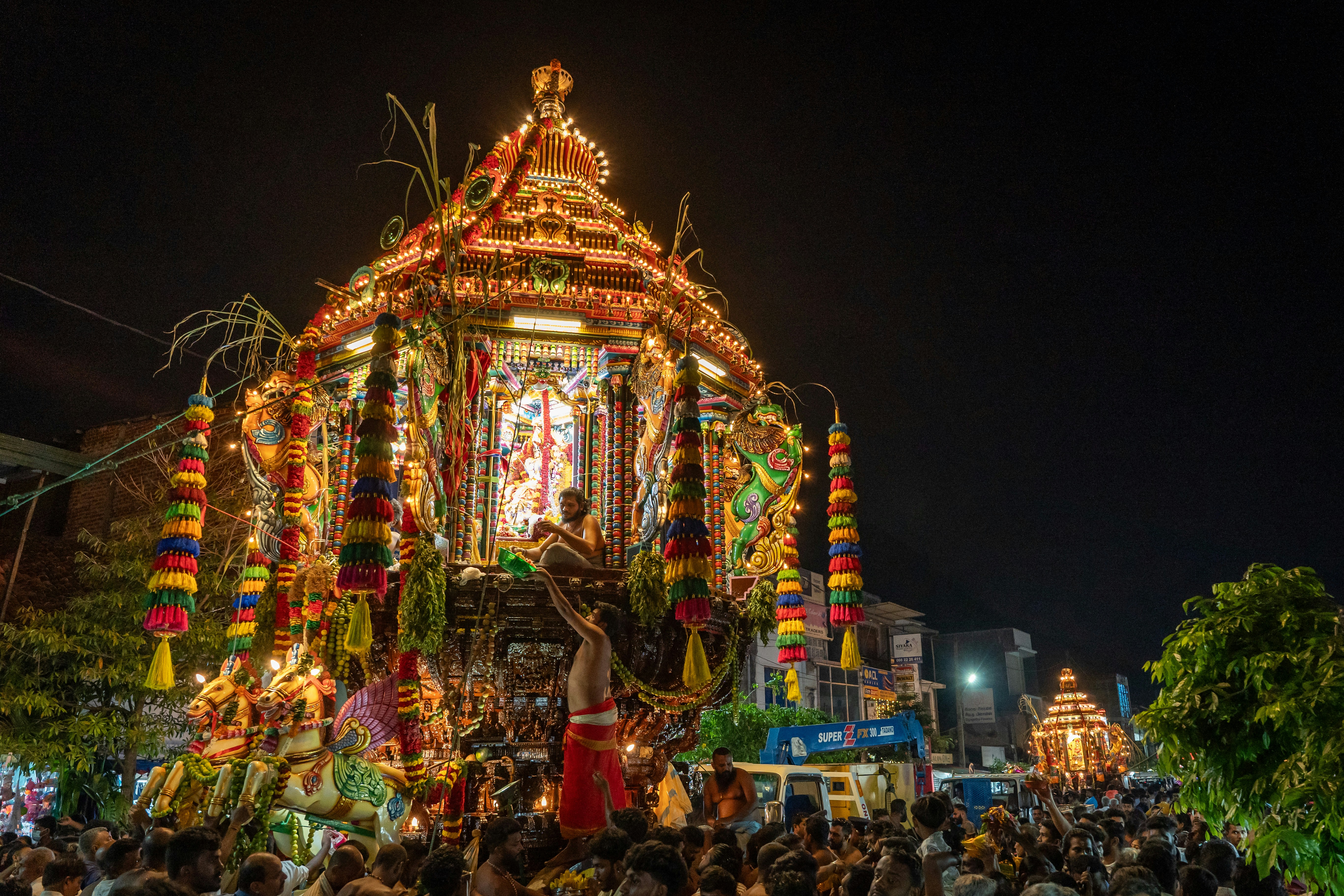Night Temple Car festival: illuminated shrine rising over a bustling crowd