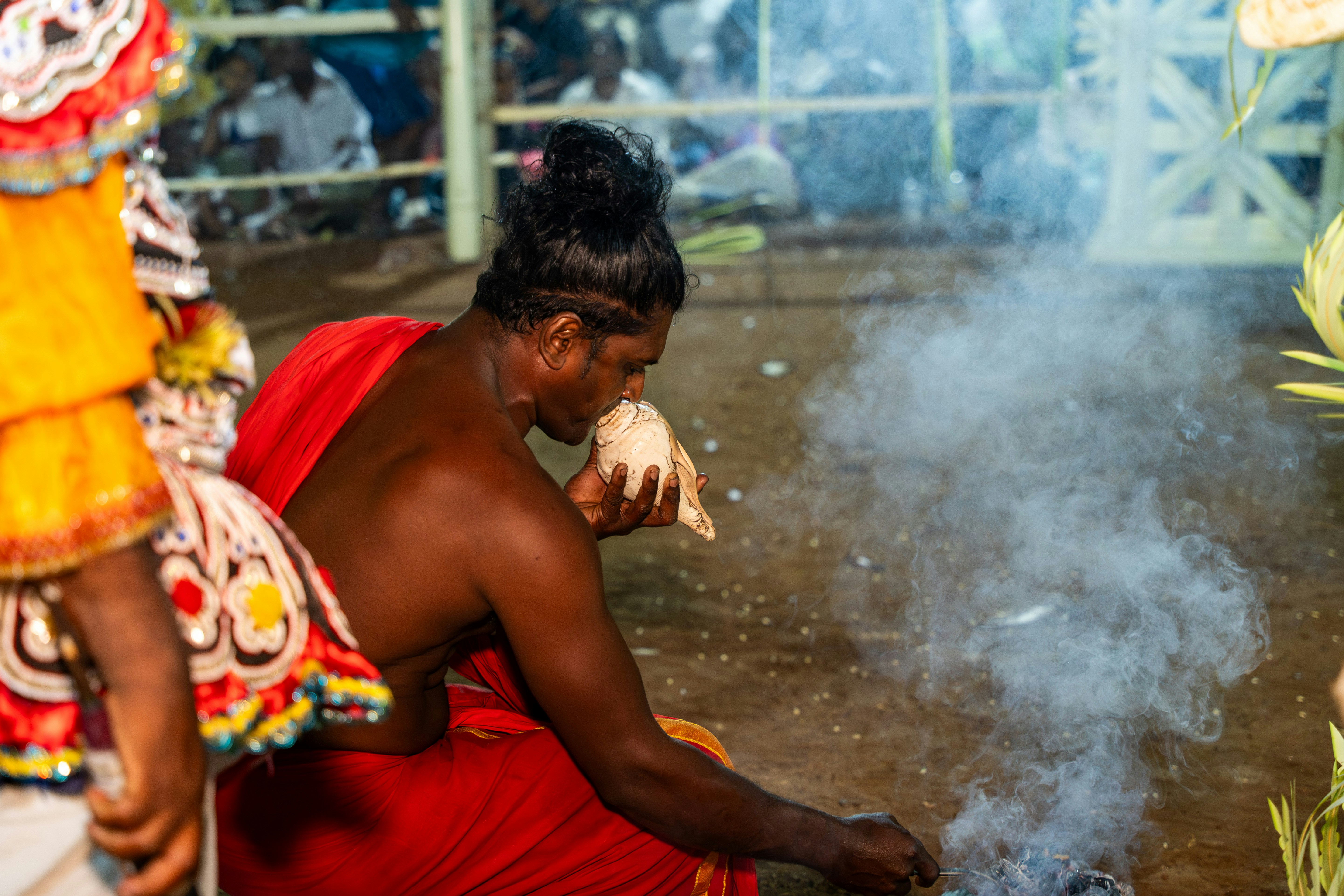 Coconut Ritual: A Devotee Clutches a Shell amid Smoldering Flames