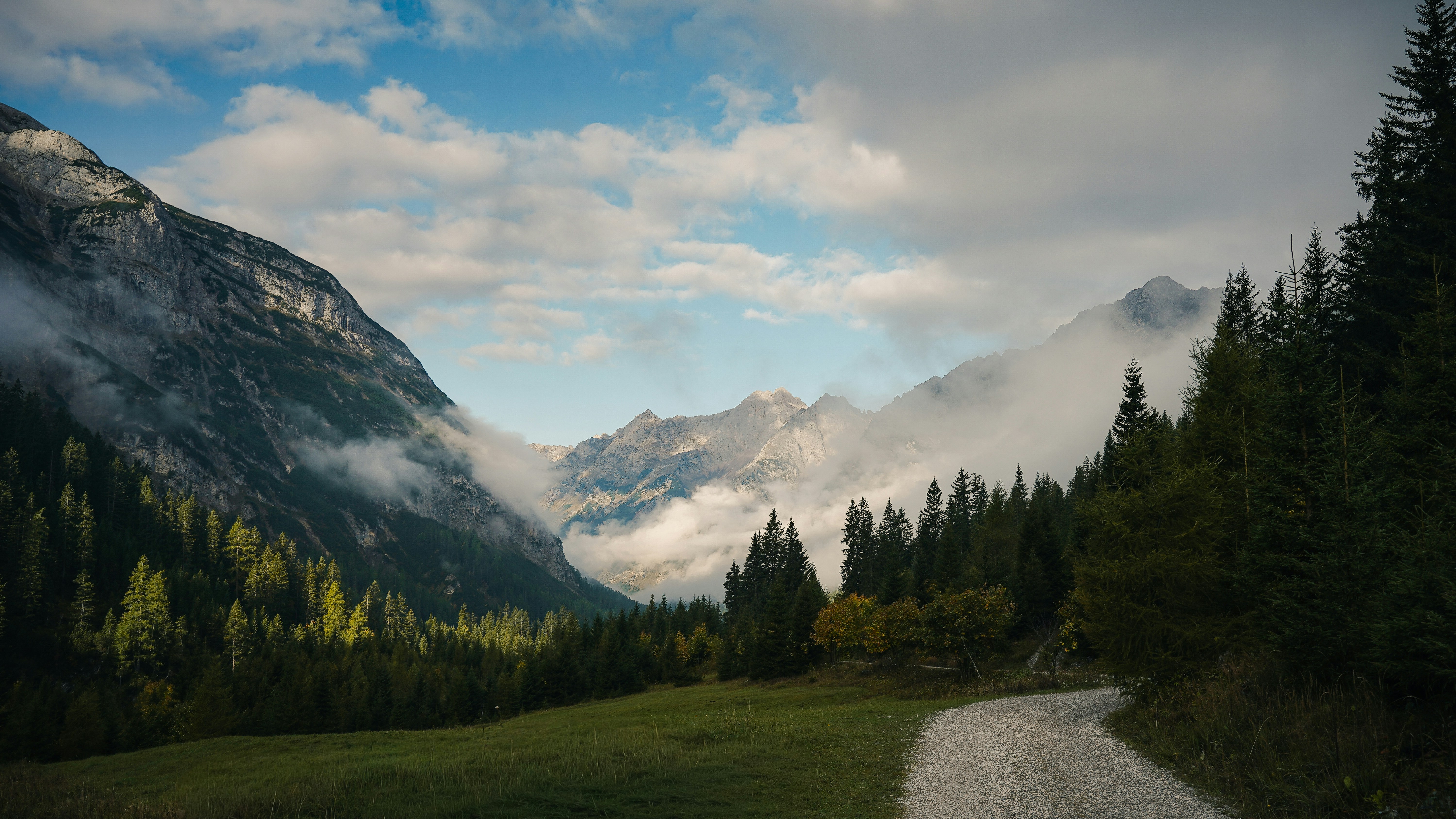 Valley Path to Cloud-Kissed Peaks