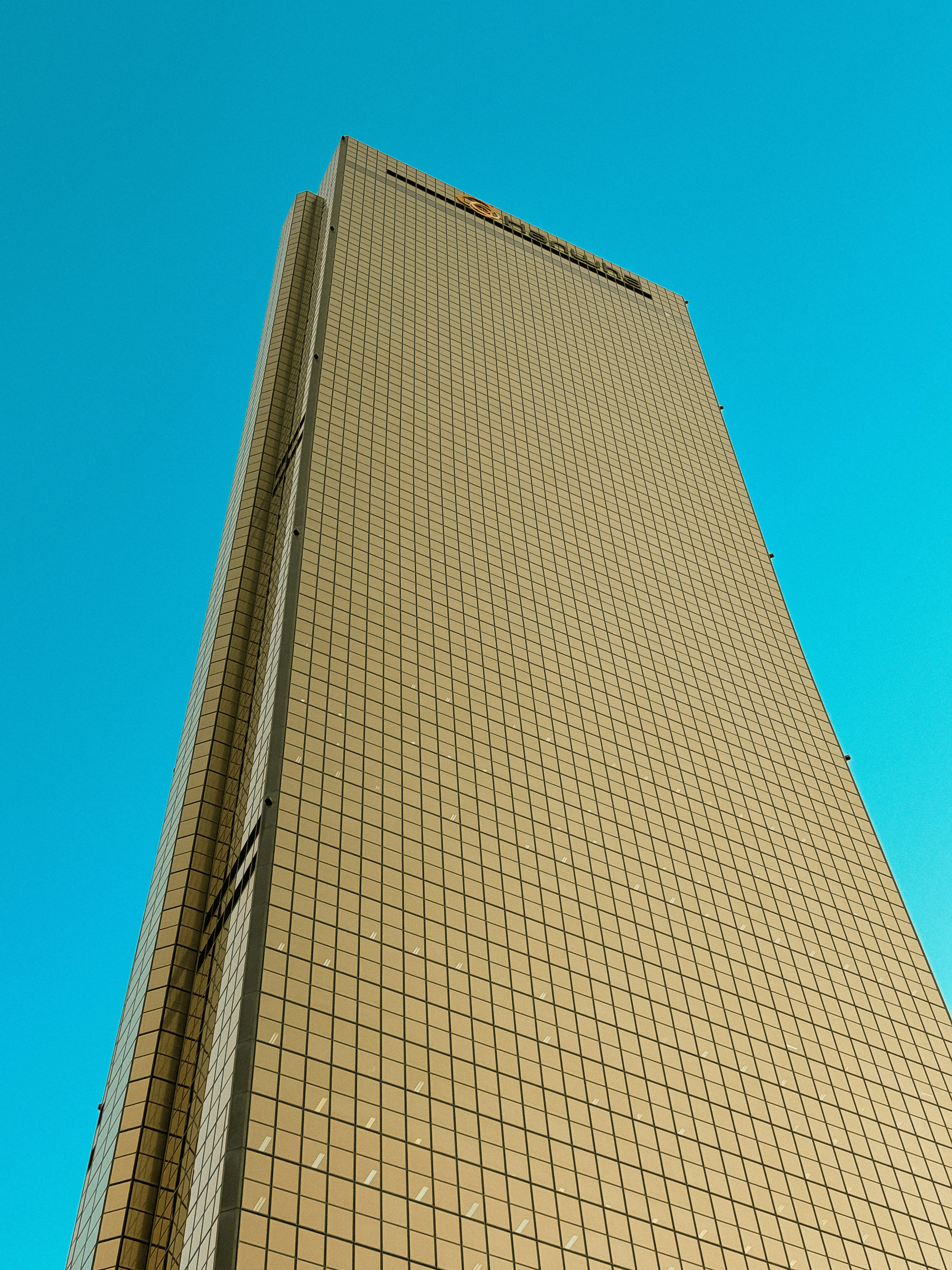 Skyward Facade: A Monolithic Tower Reaching the Blue