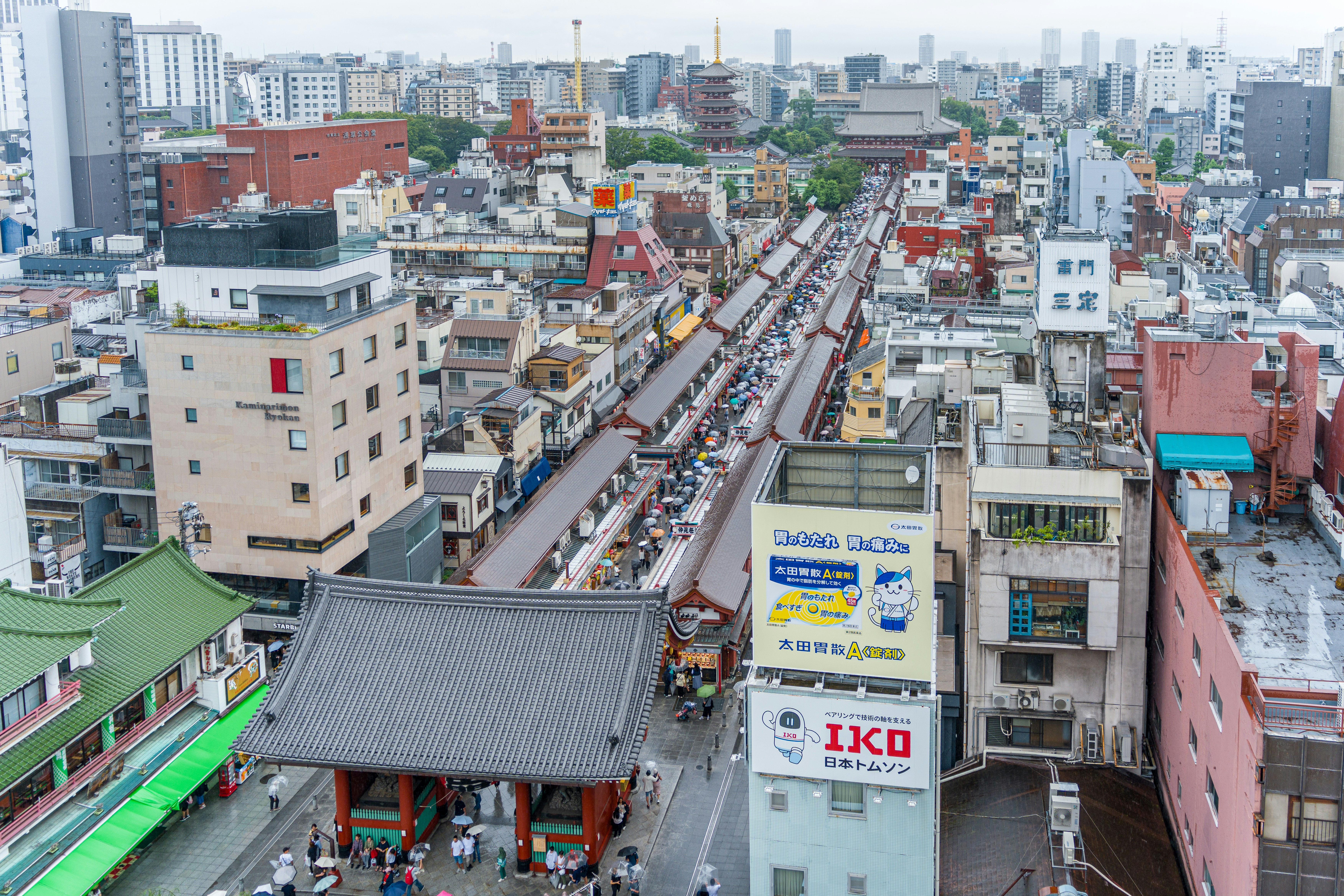 Aerial Street Corridor: Trains and Cityscape under a Narrow Skyline