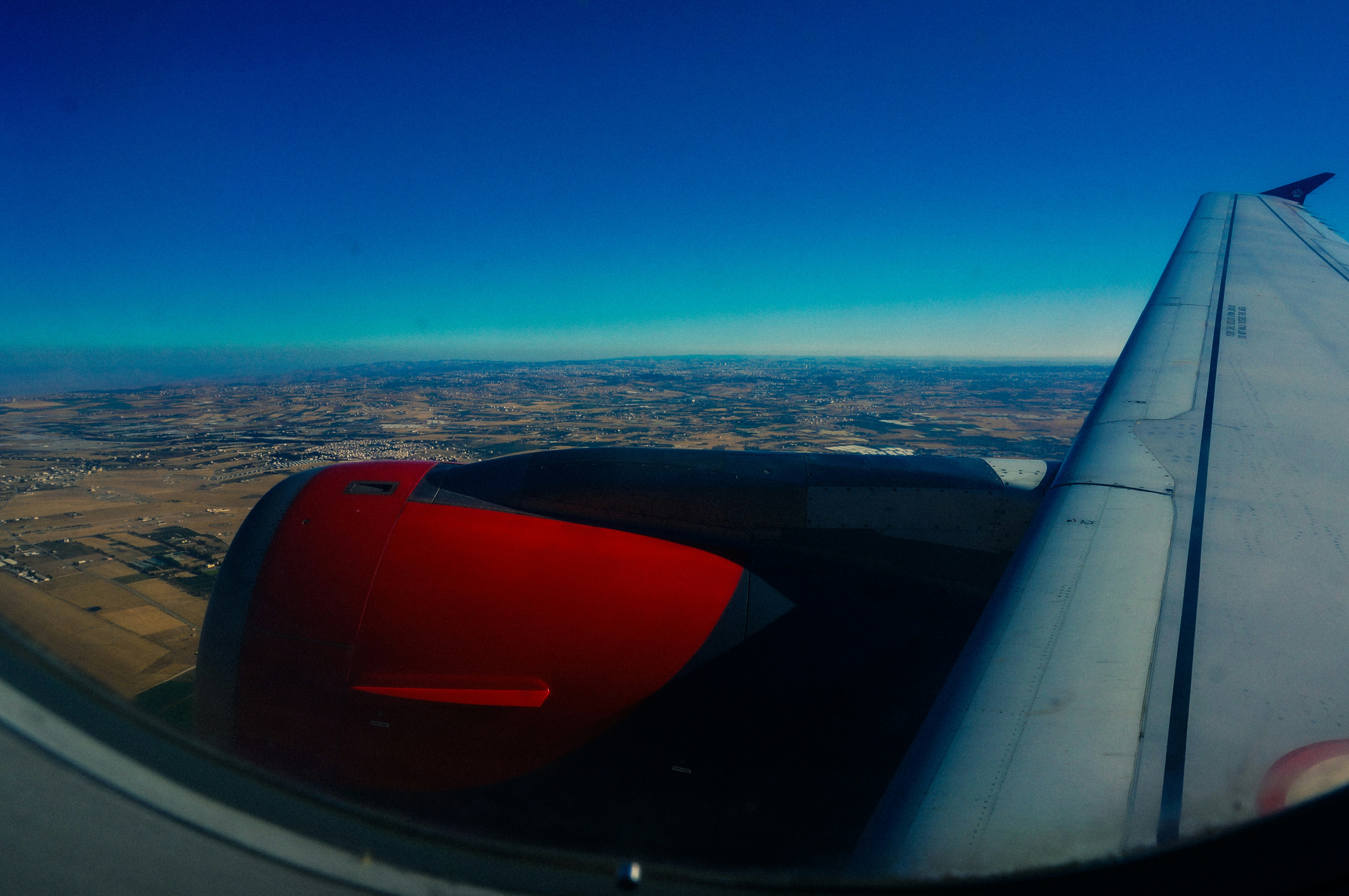 Winged Vista: Red Engine Hums Over a Quiet Continental Sky