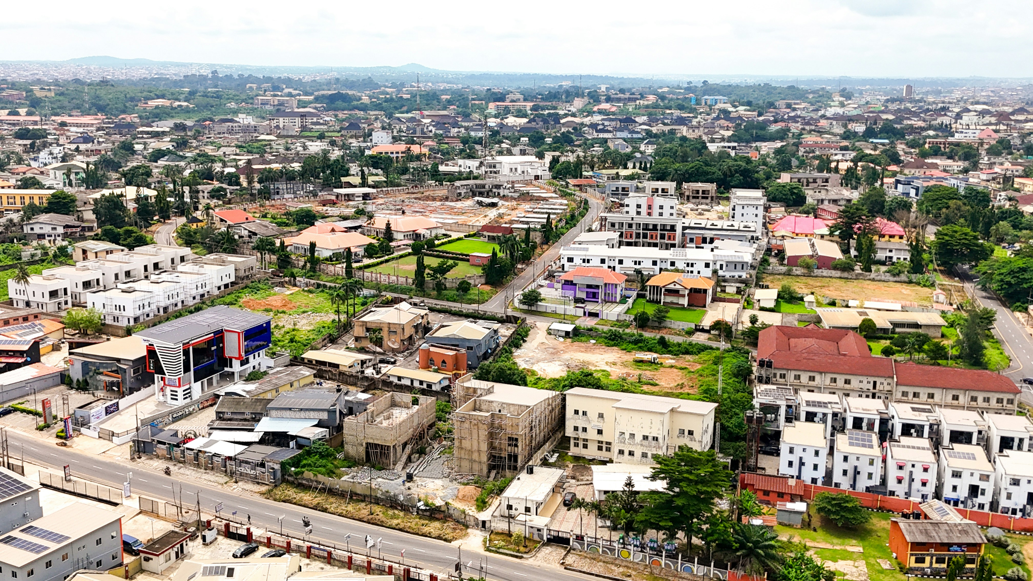 A high-resolution aerial drone photograph of Bodija, one of the most prestigious residential and commercial districts in Ibadan, Oyo State, Nigeria. This panoramic cityscape showcases modern homes, tree-lined streets, business districts, road intersections, and the evolving skyline of Ibadan. Ideal for projects related to urban development, Nigerian cities, architecture, real estate, tourism, infrastructure, smart cities, and West African landscapes. Photo by @tundeburemo