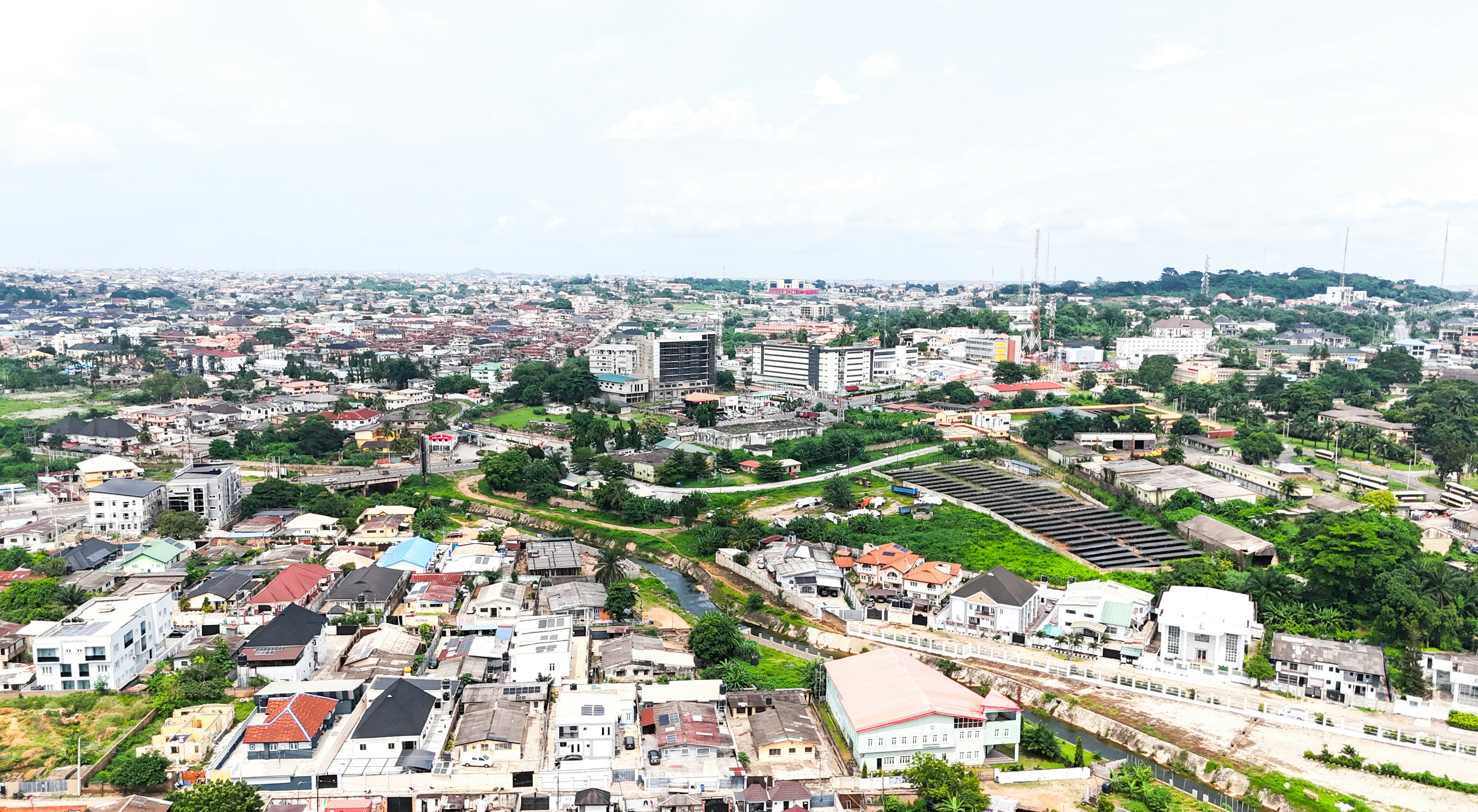 A high-resolution aerial drone photograph of Bodija, one of the most prestigious residential and commercial districts in Ibadan, Oyo State, Nigeria. This panoramic cityscape showcases modern homes, tree-lined streets, business districts, road intersections, and the evolving skyline of Ibadan. Ideal for projects related to urban development, Nigerian cities, architecture, real estate, tourism, infrastructure, smart cities, and West African landscapes. Photo by @tundeburemo