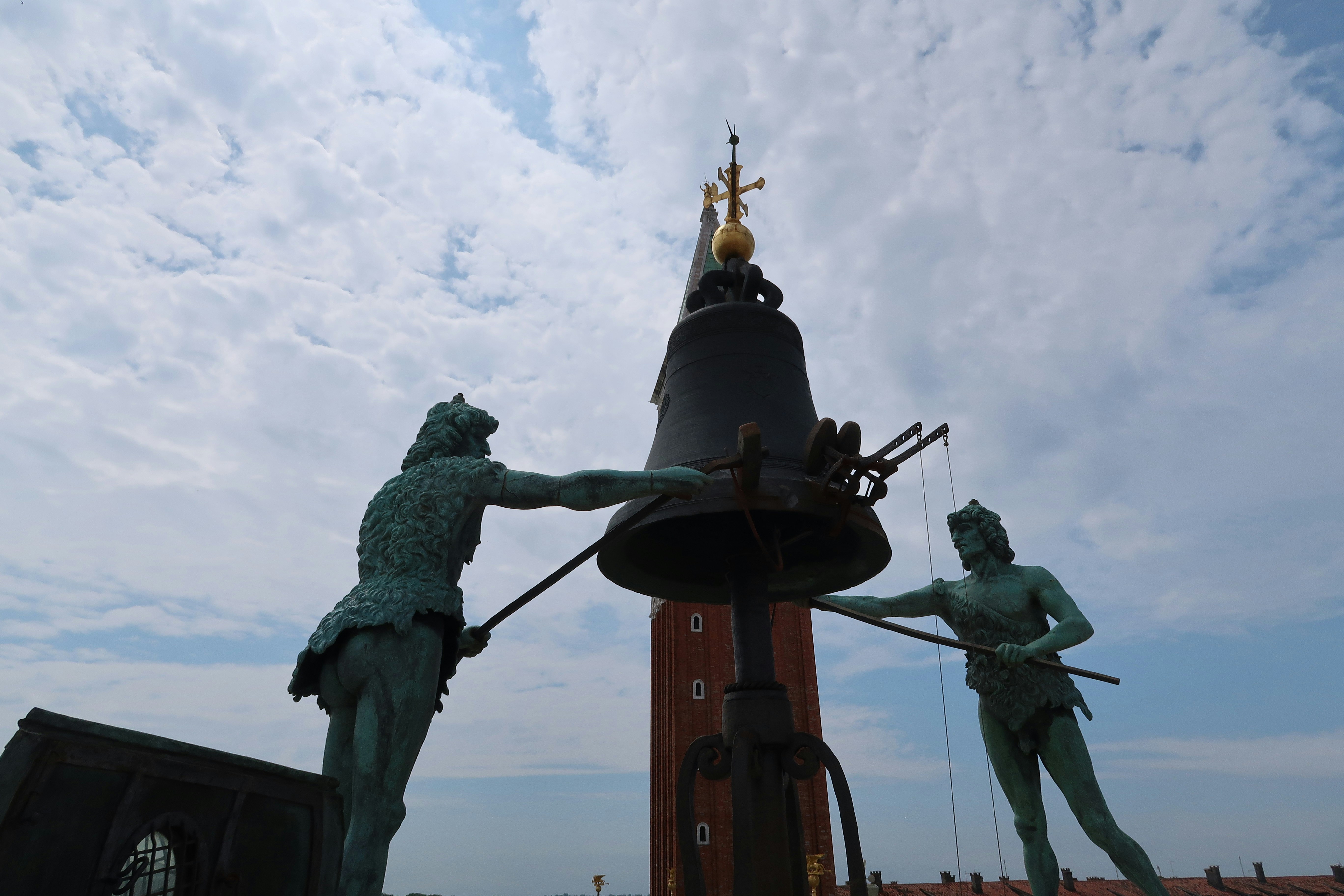 The Bell’s Reach: Two Bronze Giants Tolling Toward the Sky