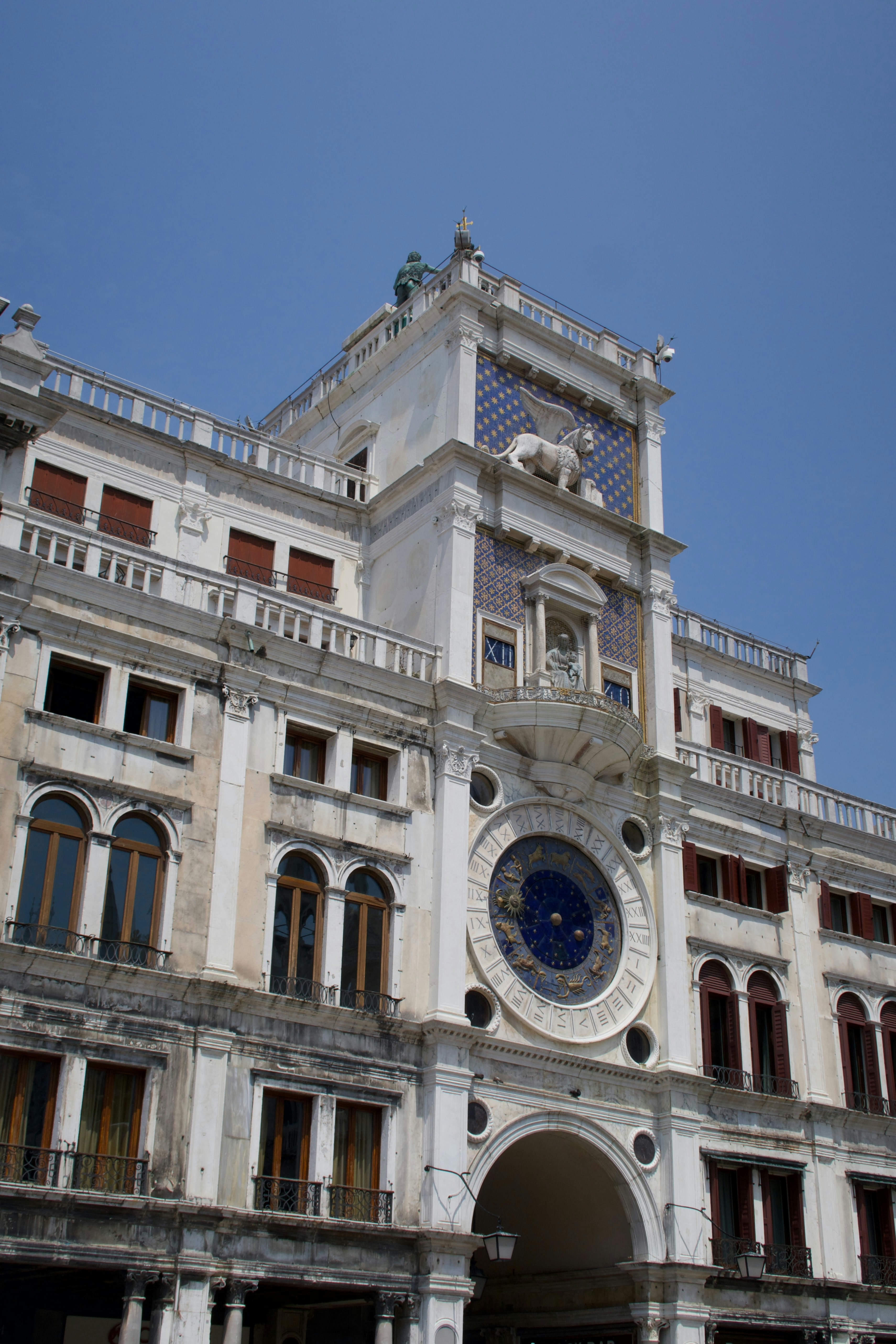 Clockwork Facade: A Venetian-Style Arch Framed by Clear Sky