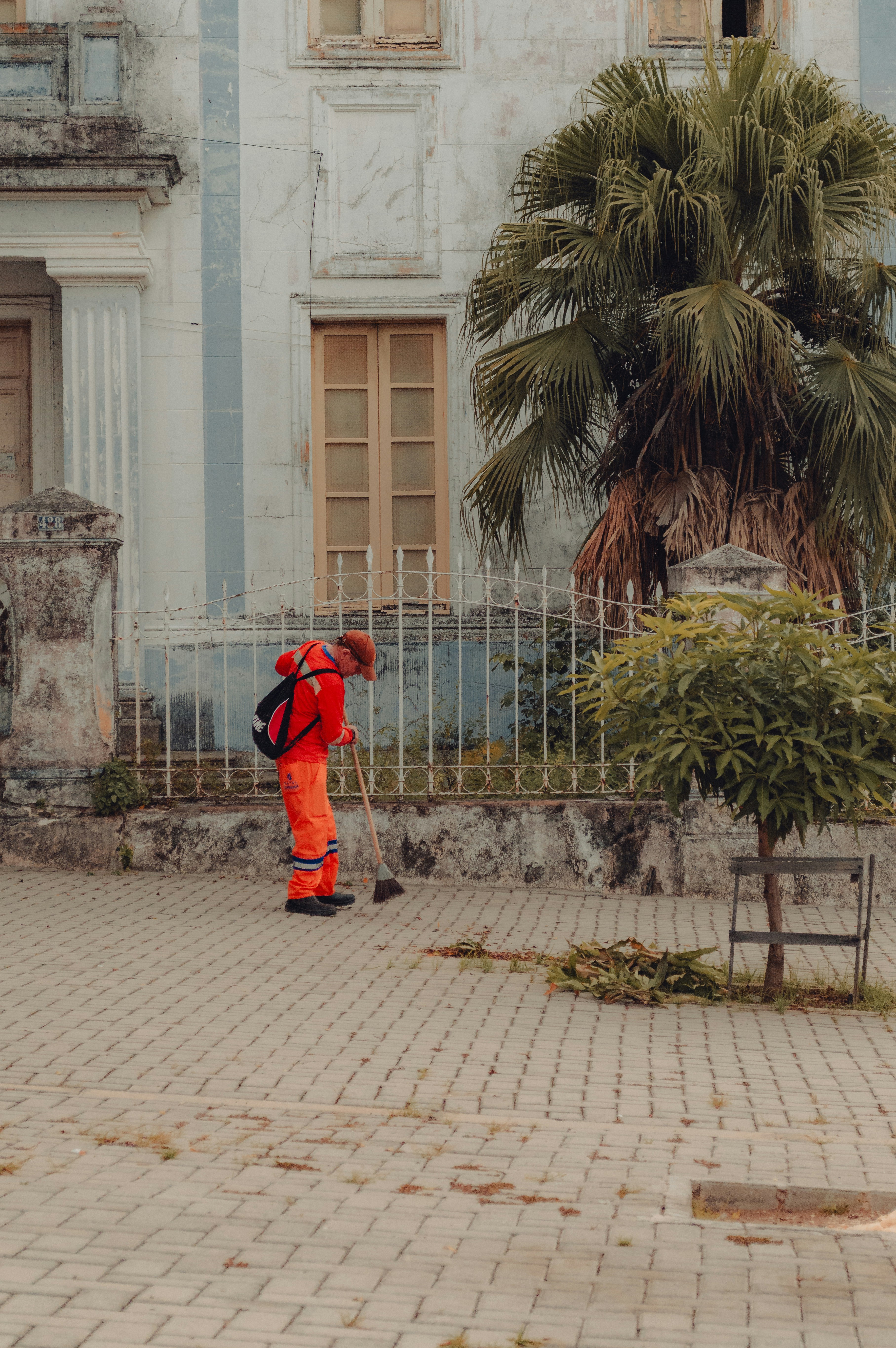 Lone street worker in the shadow of a faded villa