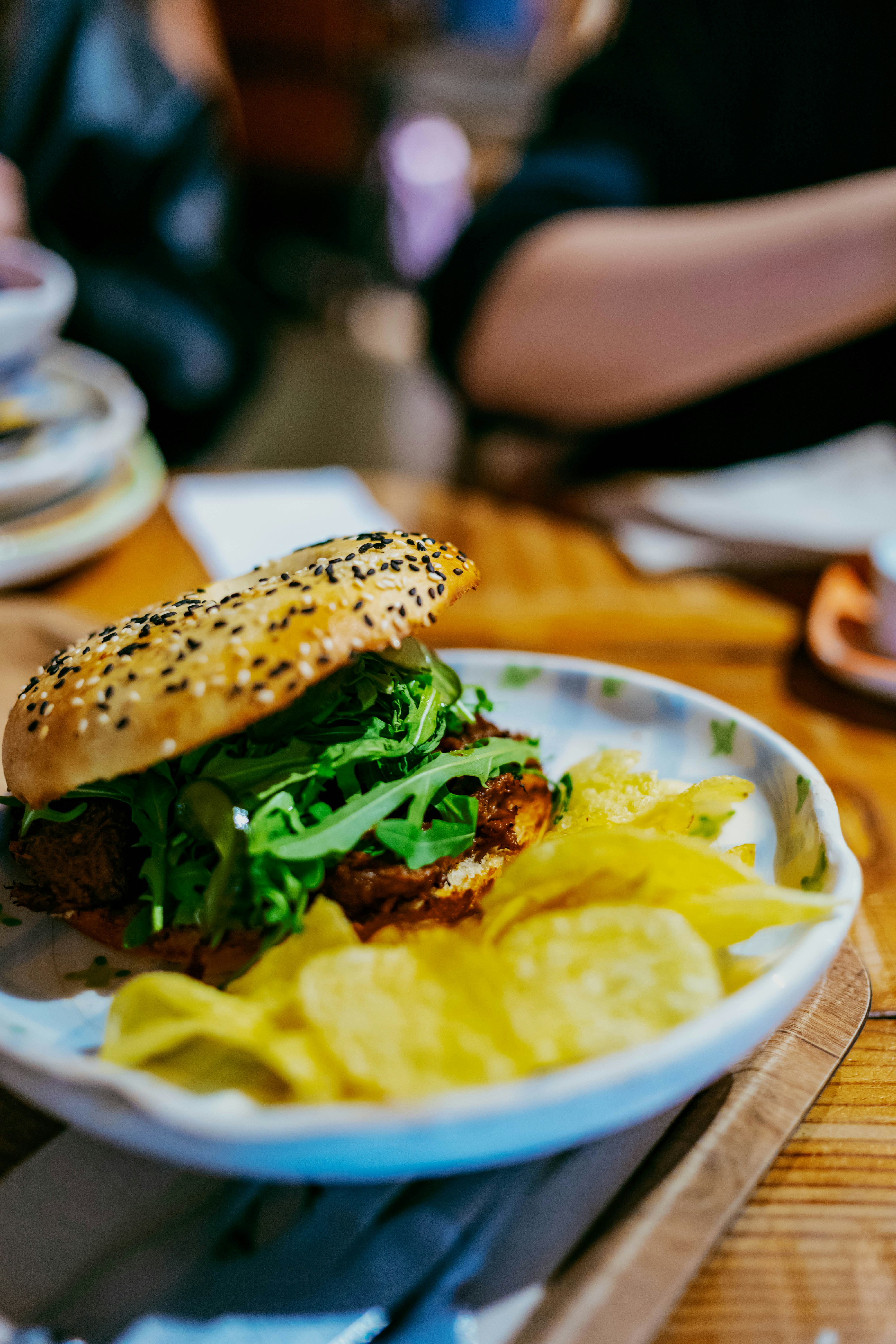 Sesame Seeded Burger on a Bed of Greens with Crunchy Chips